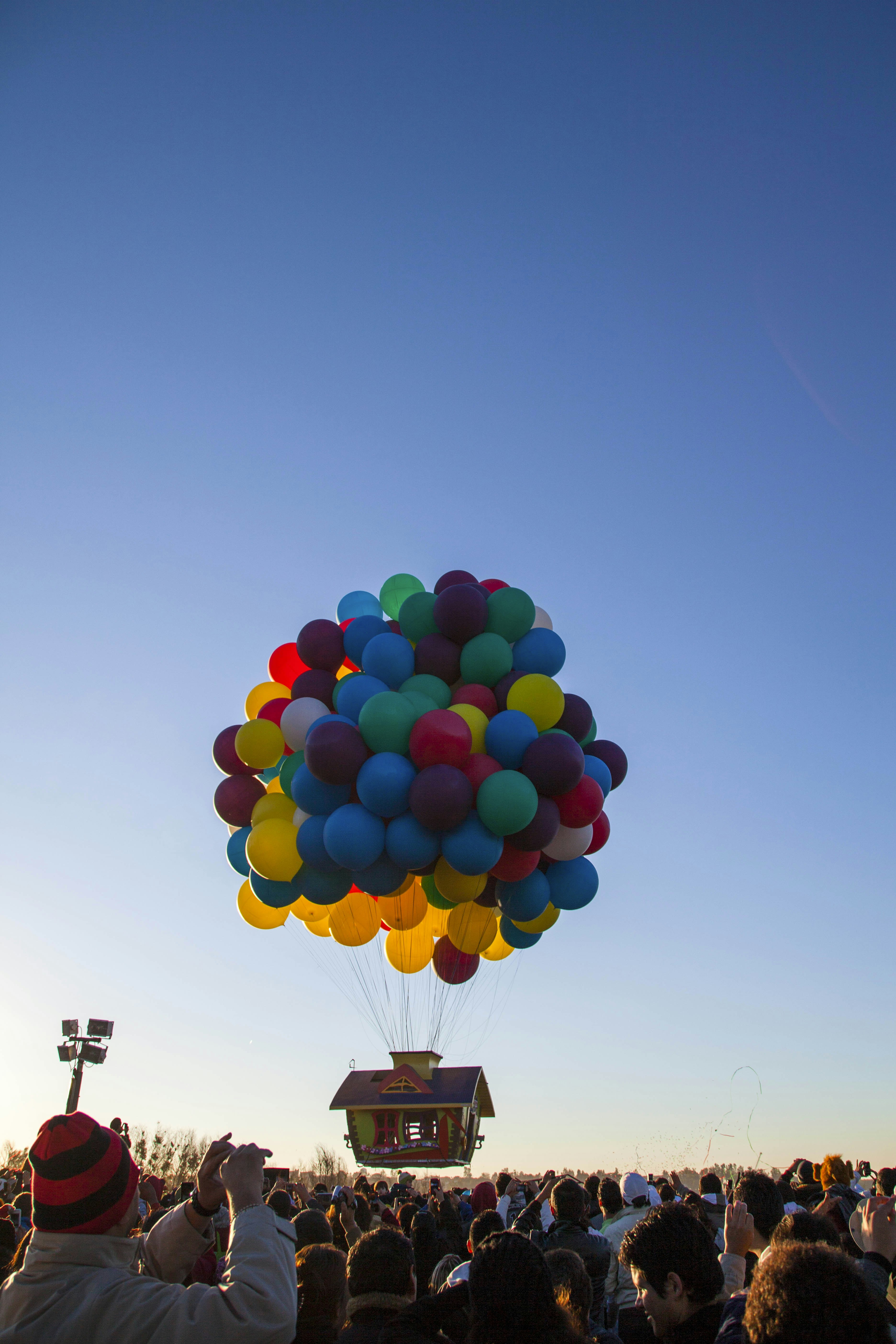 A large group of people watching a house fly in the sky photo – Free ...