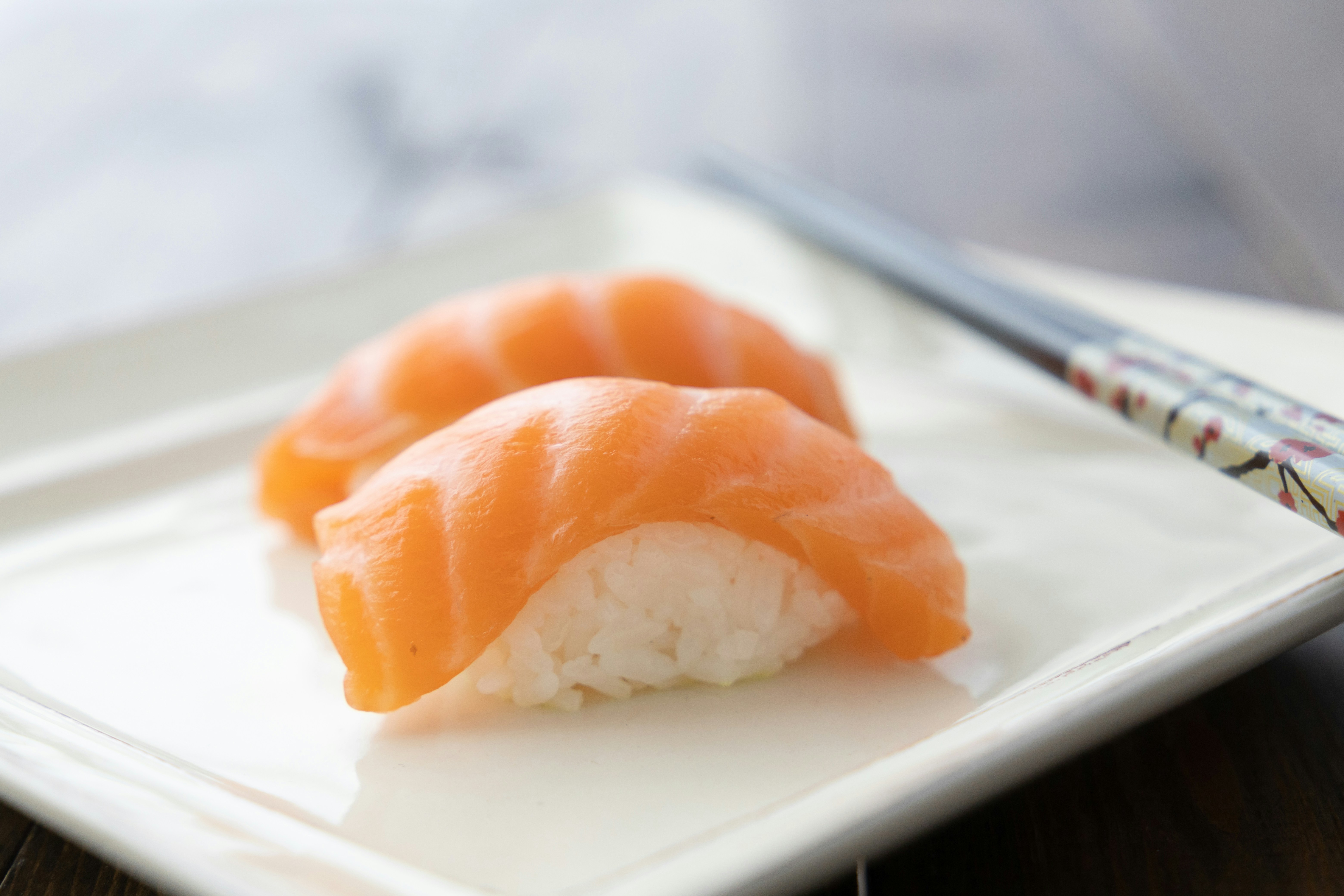 Sashimi on a white ceramic plate. | sliced fruit on white ceramic plate