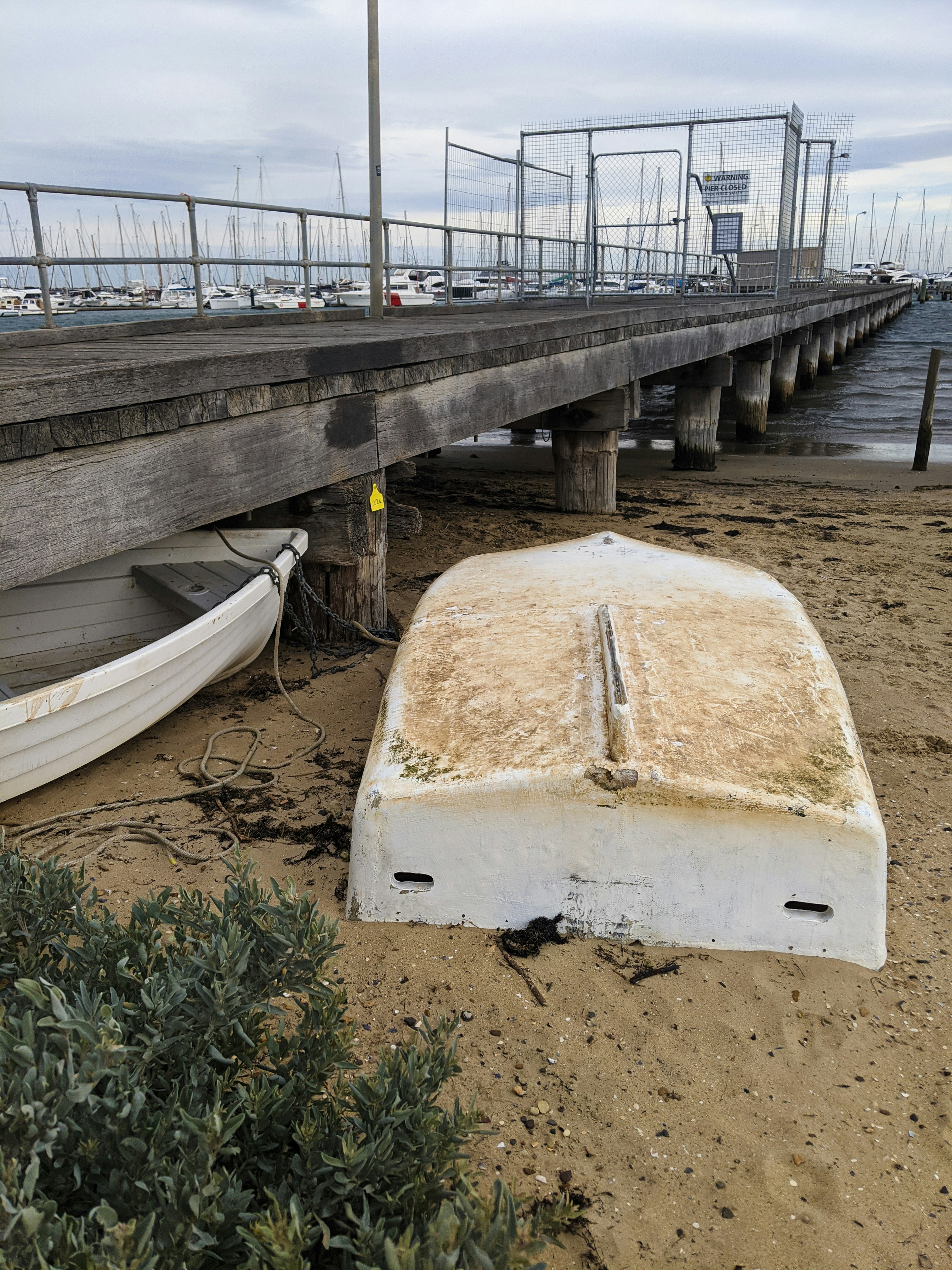 Weathered boats and a quiet pier resting on sandy shore
