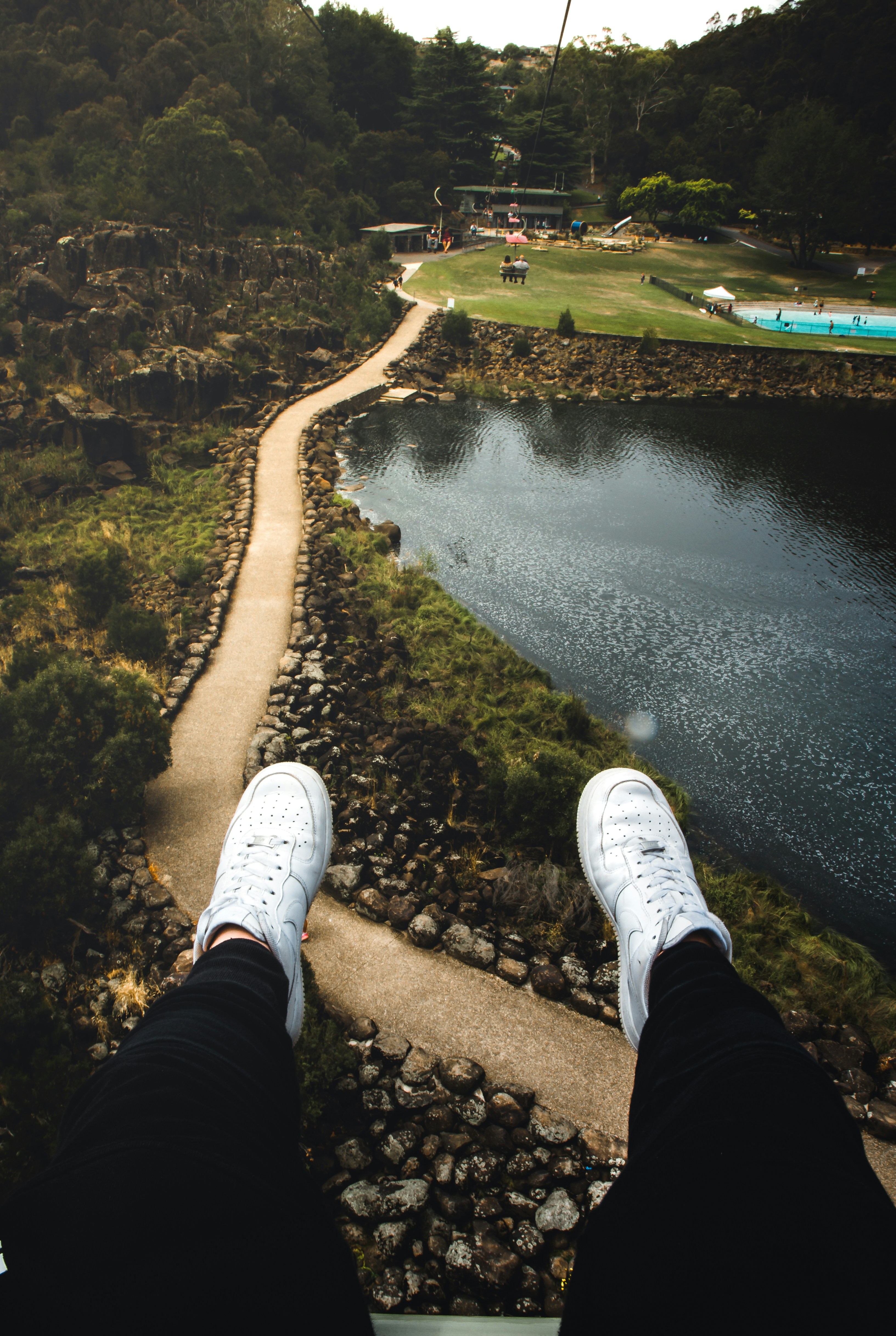 Over the Edge: White Sneakers Framing a Winding Path to a Lakeside Park
