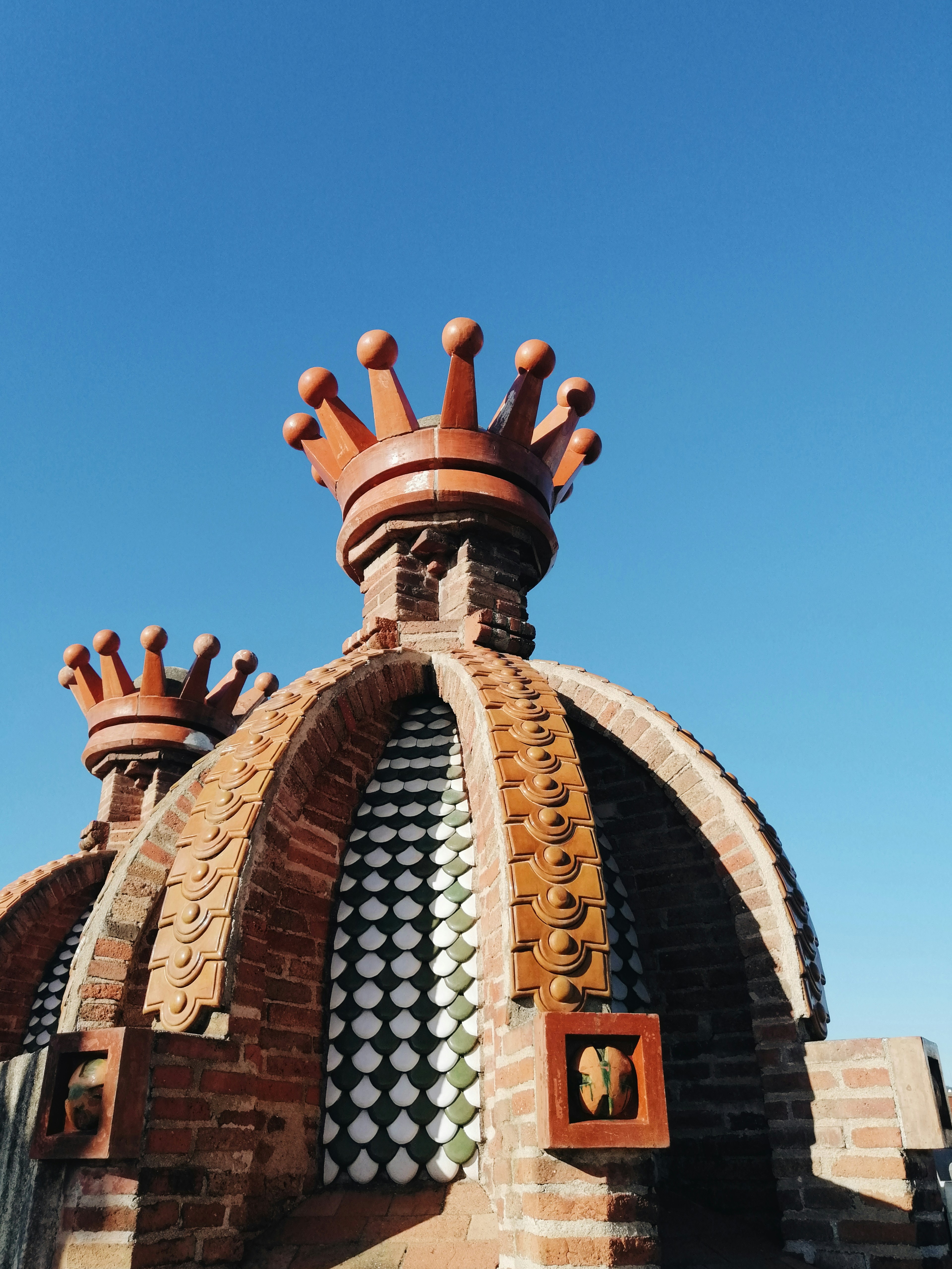 Crowning Brickwork: A Tower of Ceramic Spires Against a Clear Sky