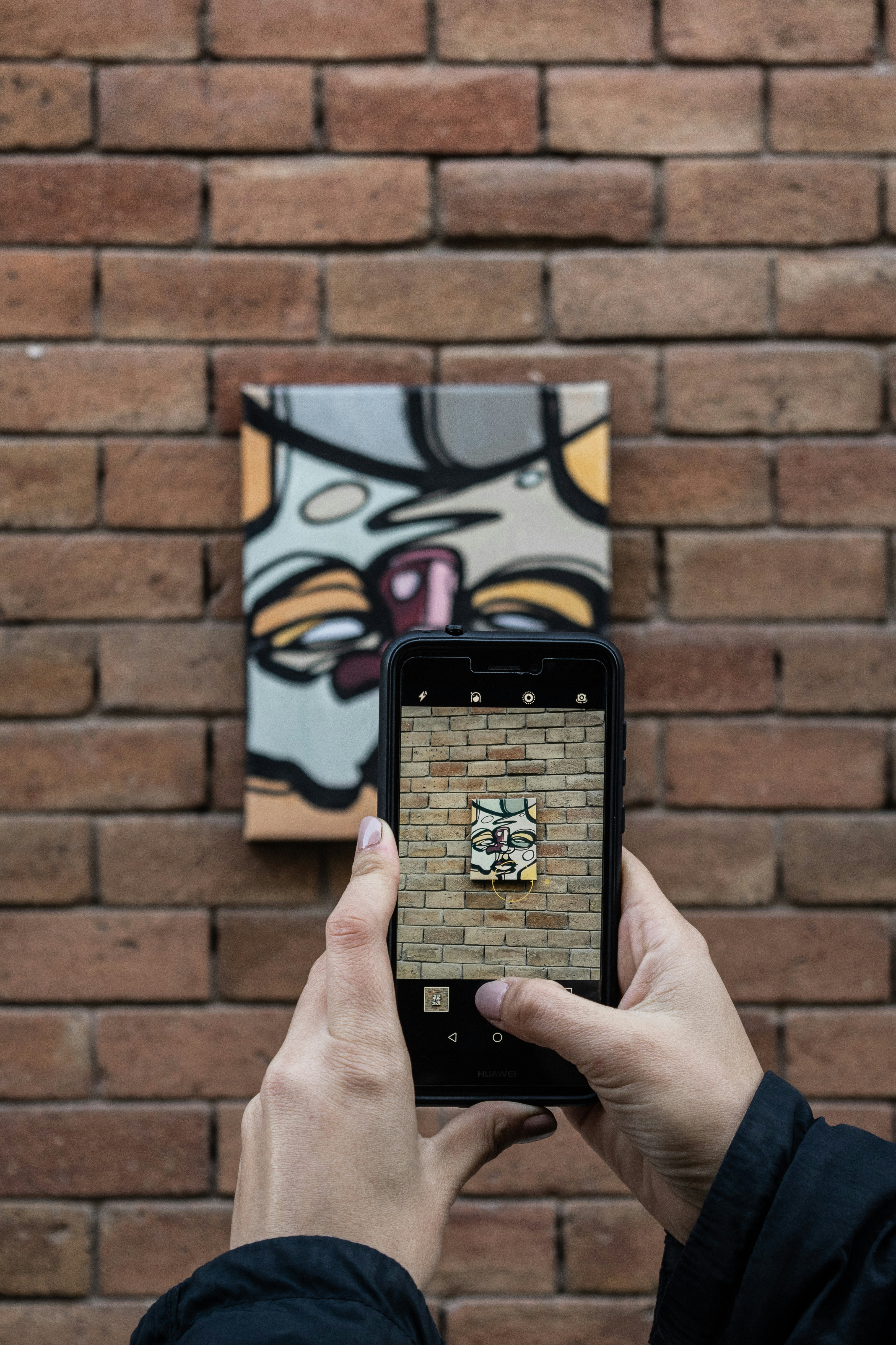 Brick-Walled Tiny Portrait: A Playful Mural Framed by a Smartphone Moment
