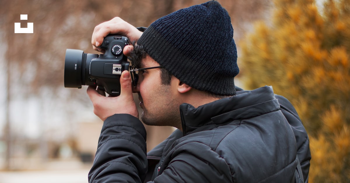 검은 색 Dslr 카메라를 들고 검은 색 재킷과 니트 모자를 쓴 남자 사진 Unsplash의 무료 검정 이미지