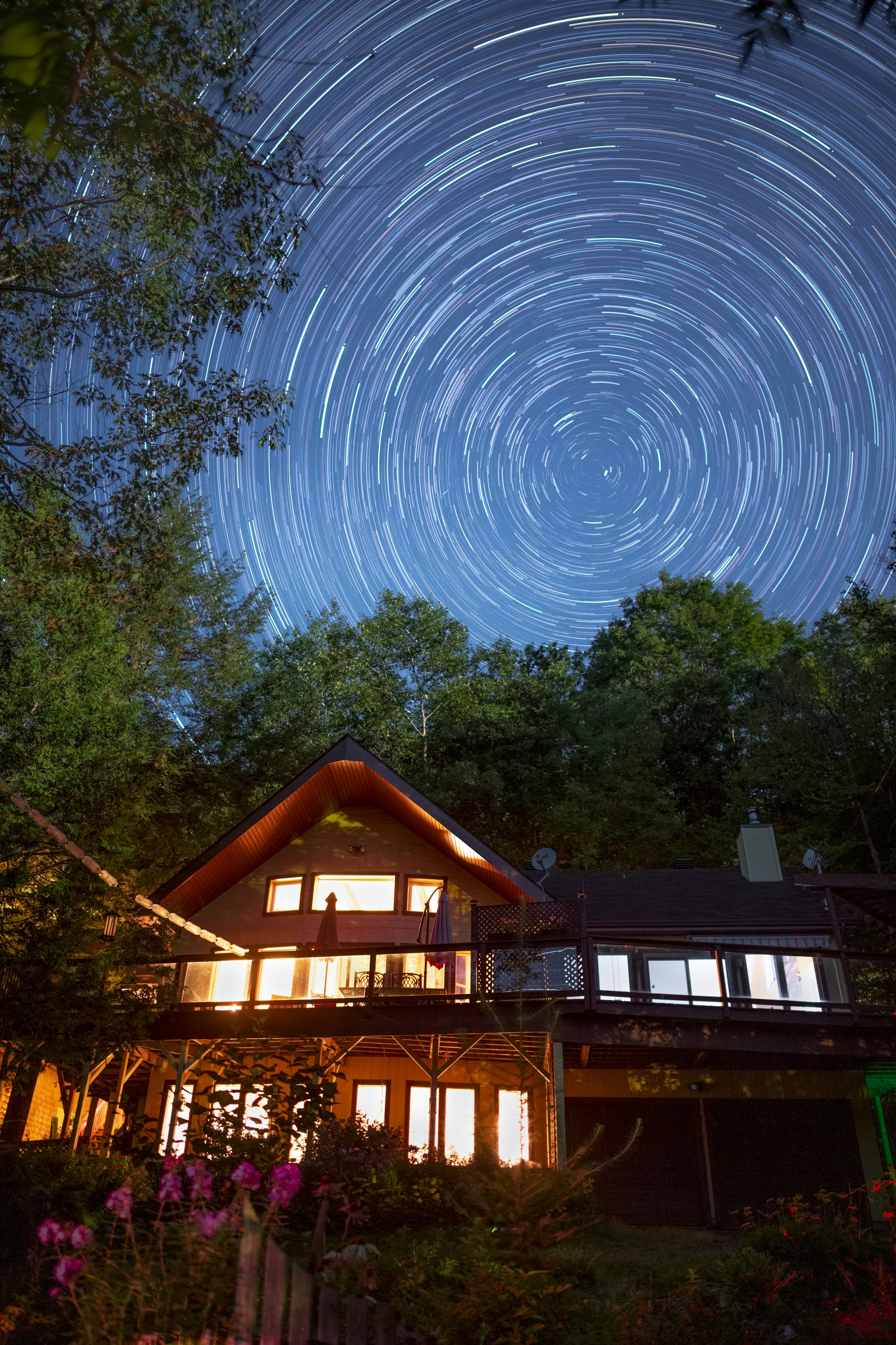 Star Trails Over a Cozy Cabin: Night Sky Circles Above Warm Light