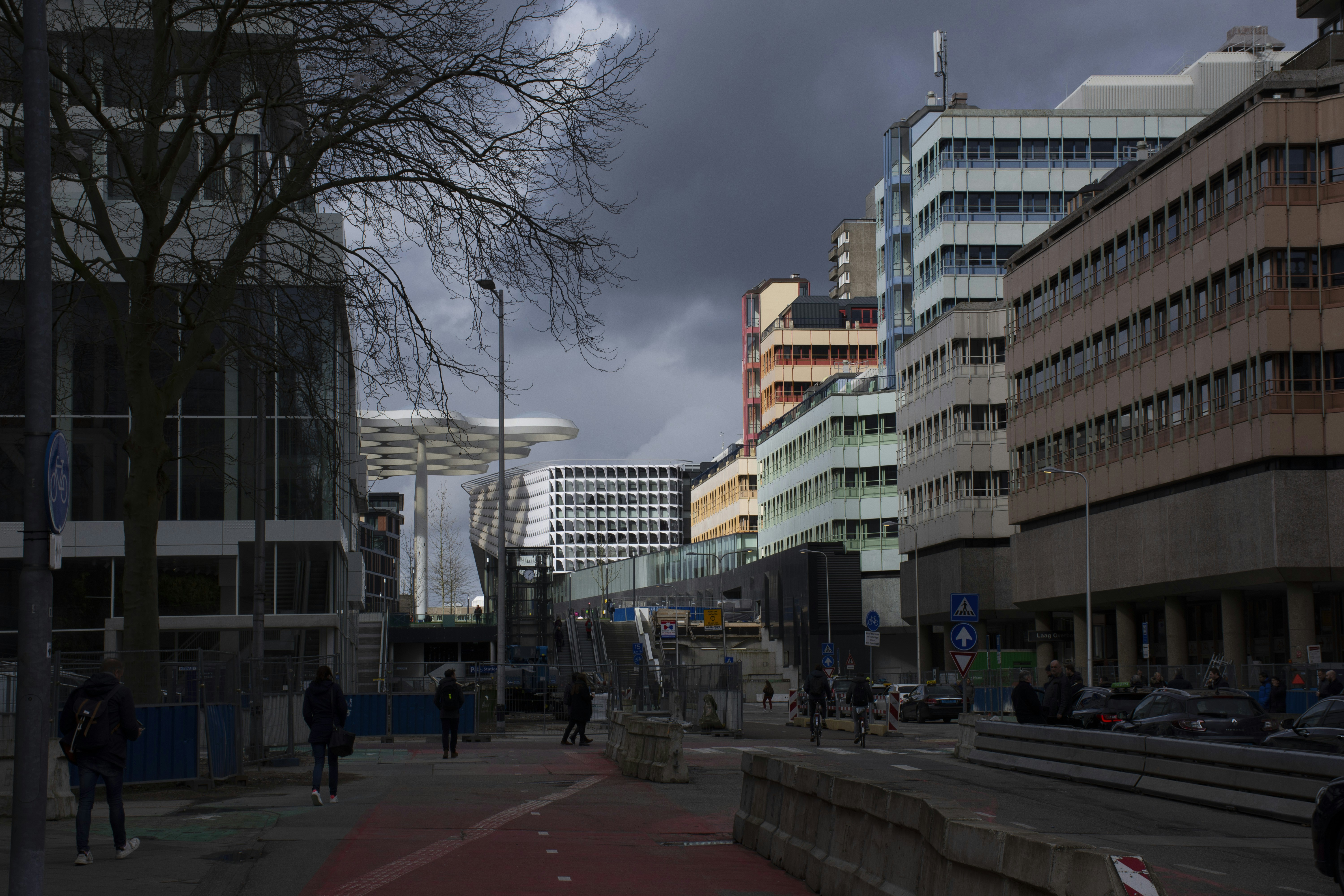 City street with modern architecture under dark clouds.