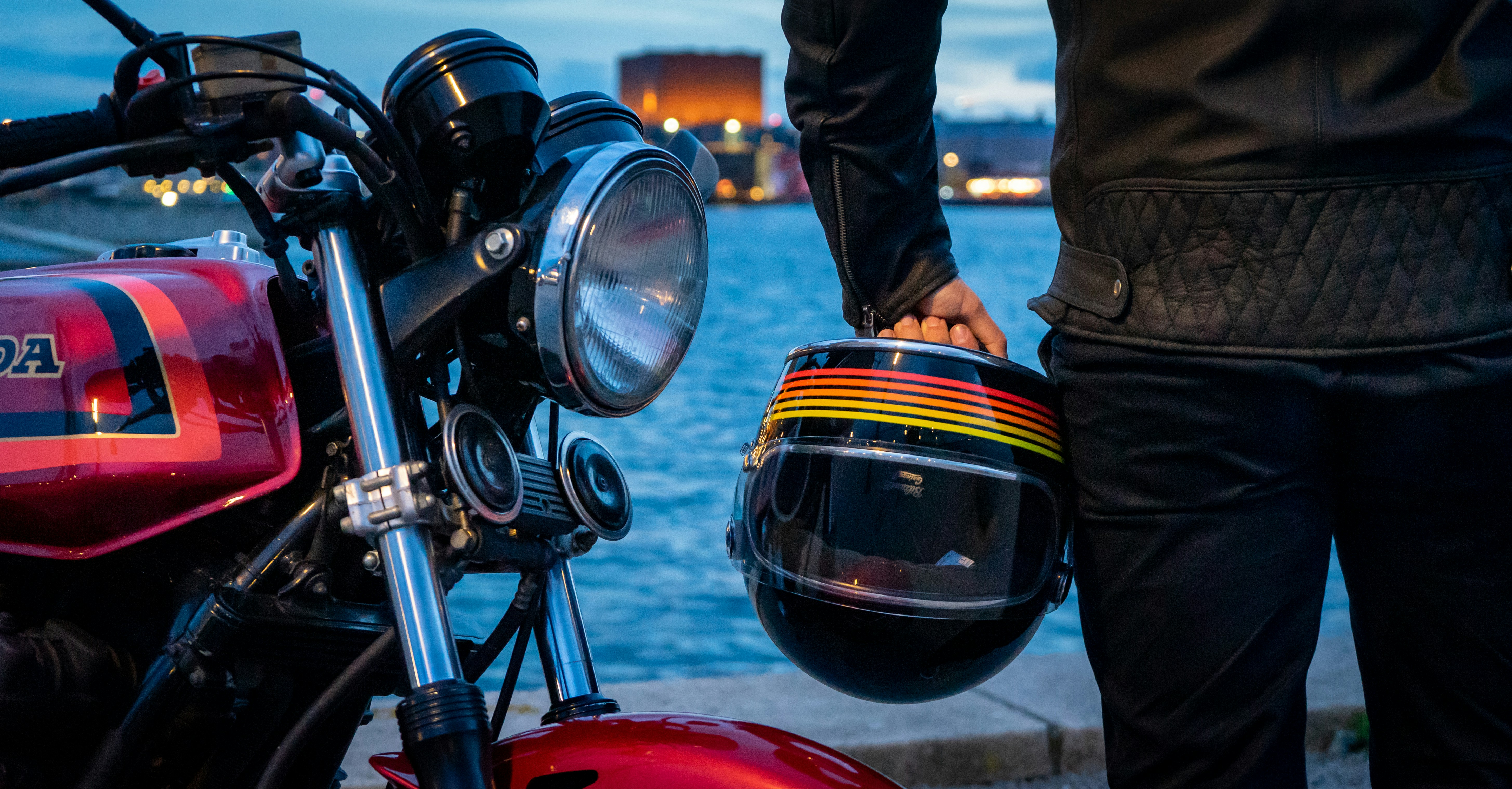 Handshake with the Rider: A Helmeted Moment Beside the Classic Red Motorcycle