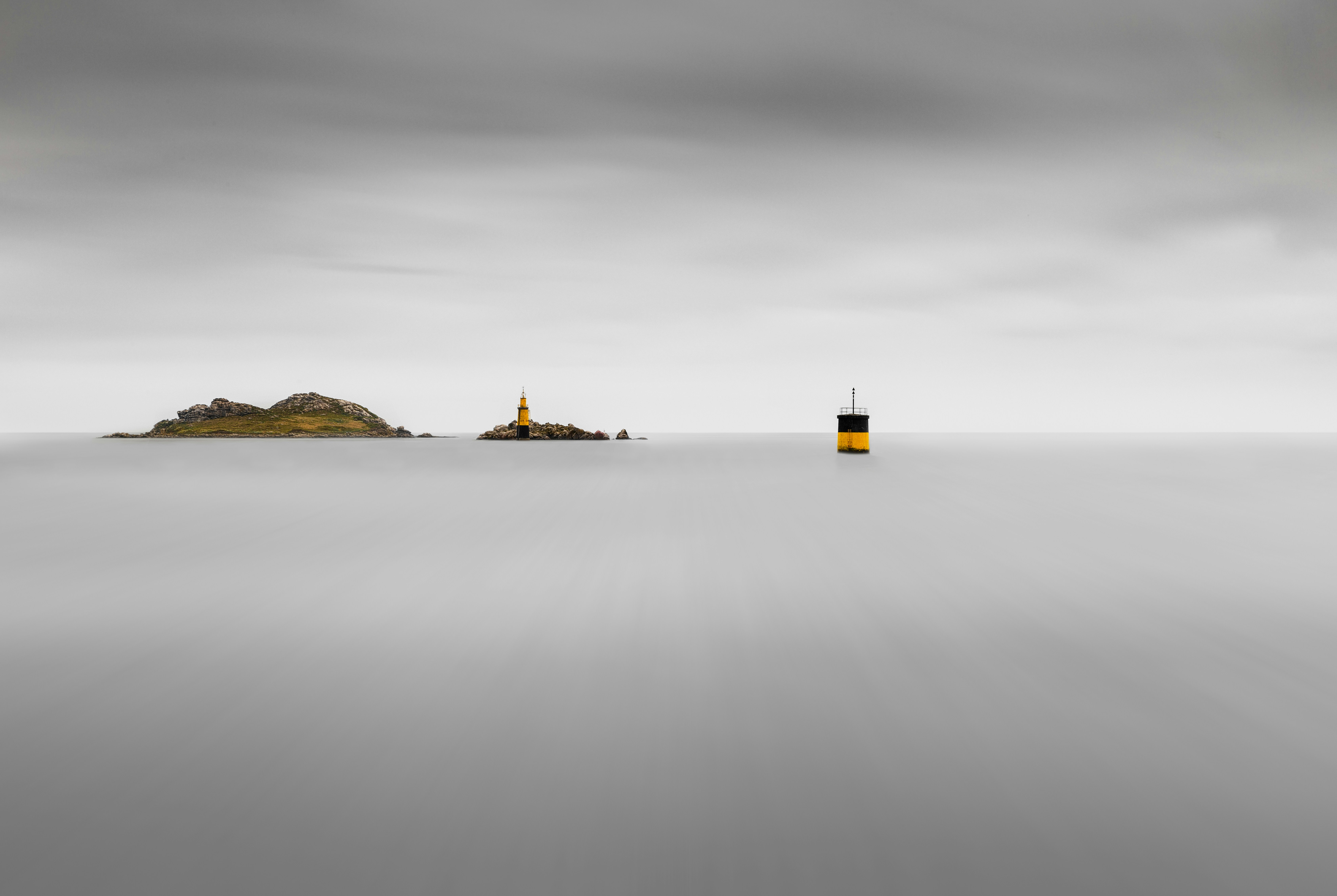 yellow and black lighthouse on top of hillFabien BELLANGER