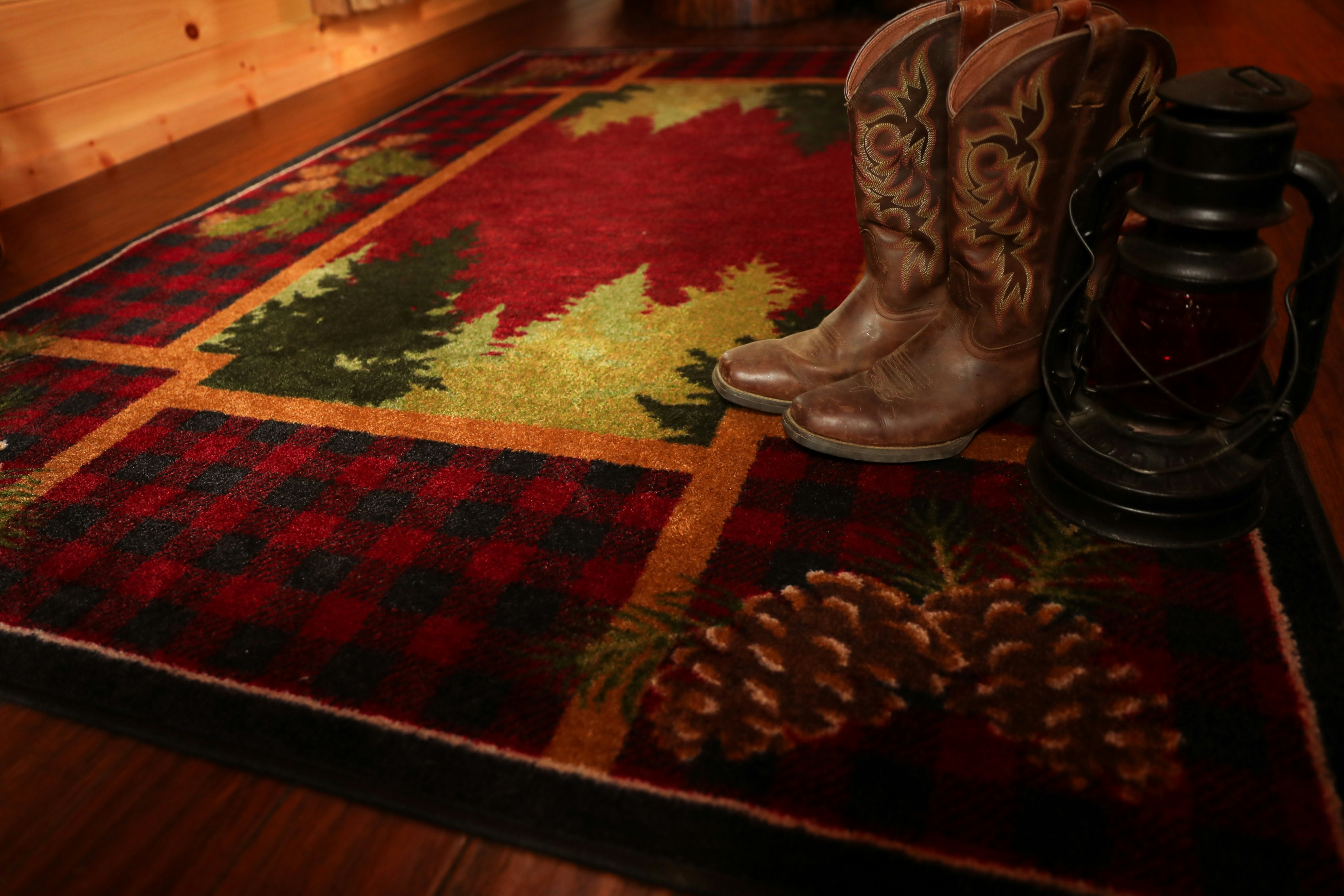 Boots at the Threshold: Pine Cones and Lantern on a Plaid Cabin Rug