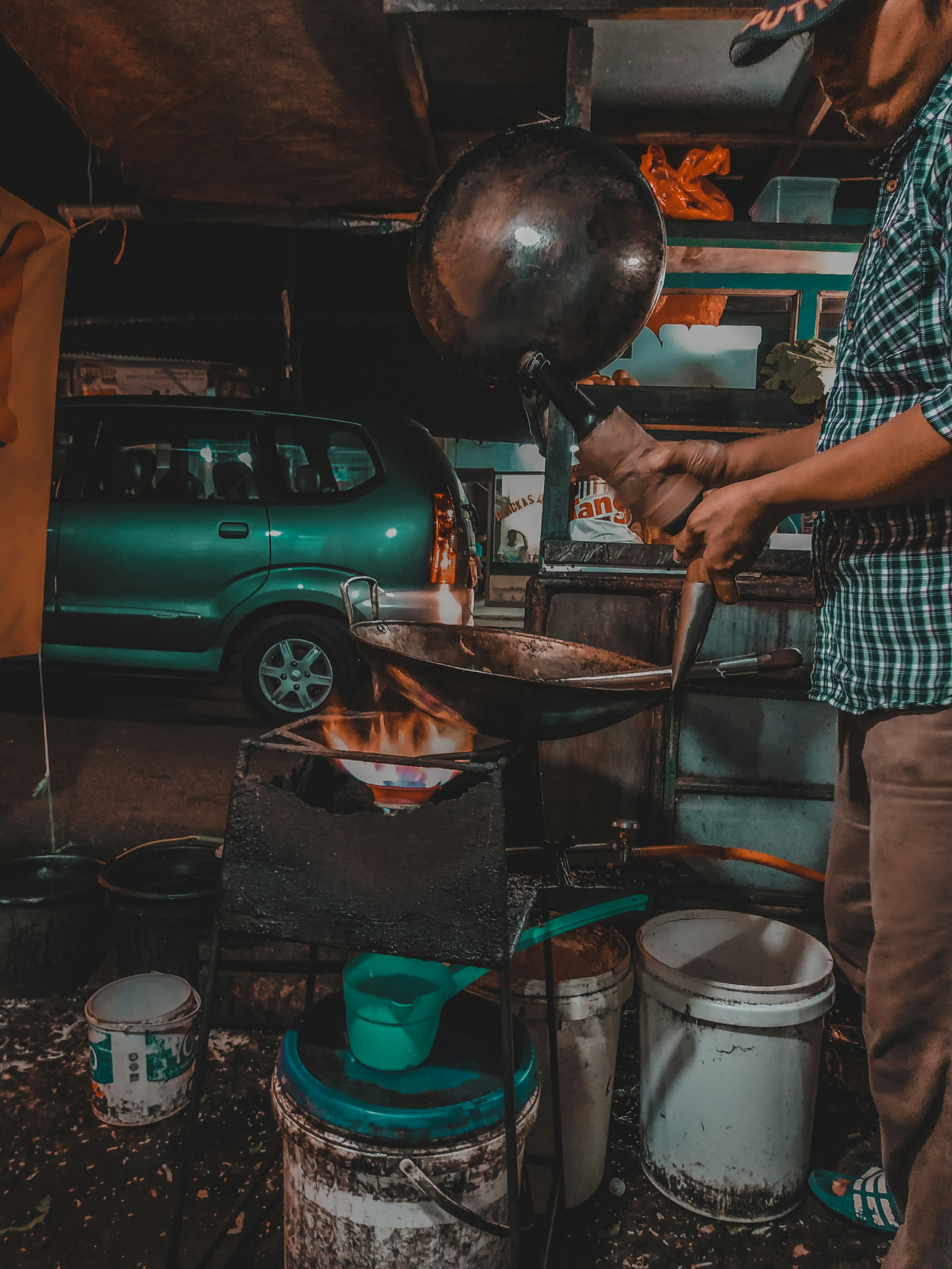 man in black and white checkered shirt holding black frying pan