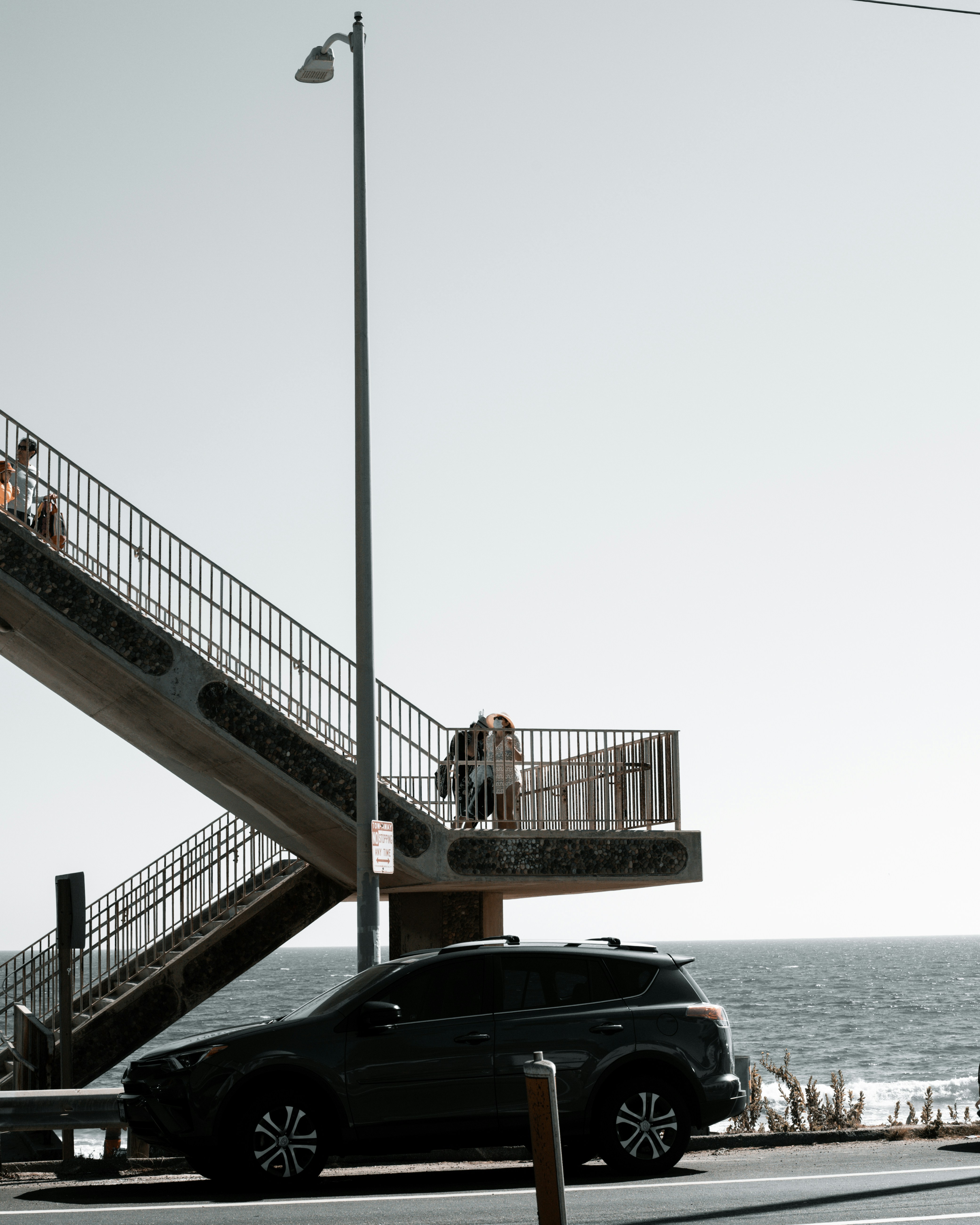 Staircase Rendezvous by the Sea with a Parked SUV