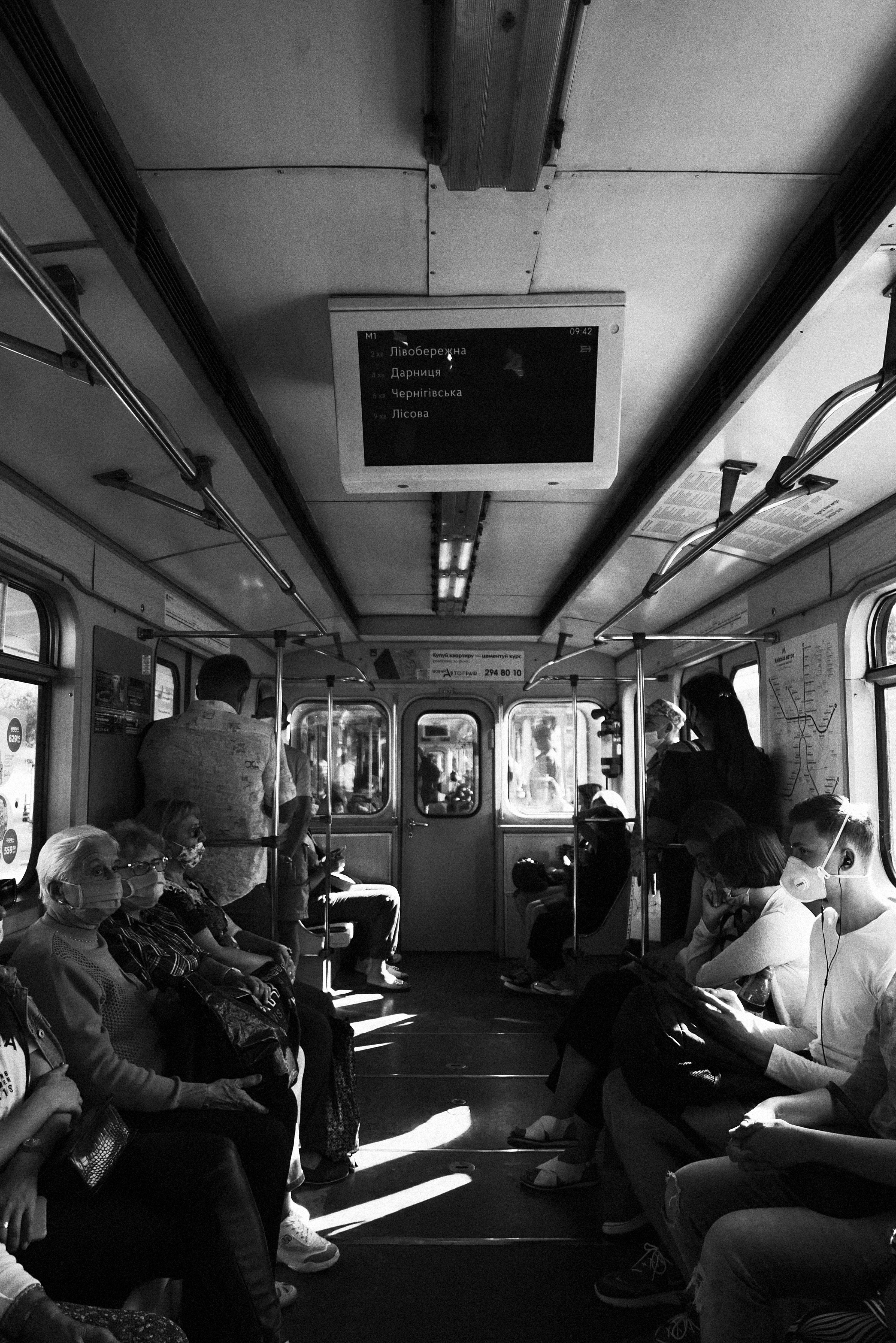 Interior view of a subway train filled with passengers, showcasing the everyday commute in a monochrome aesthetic.