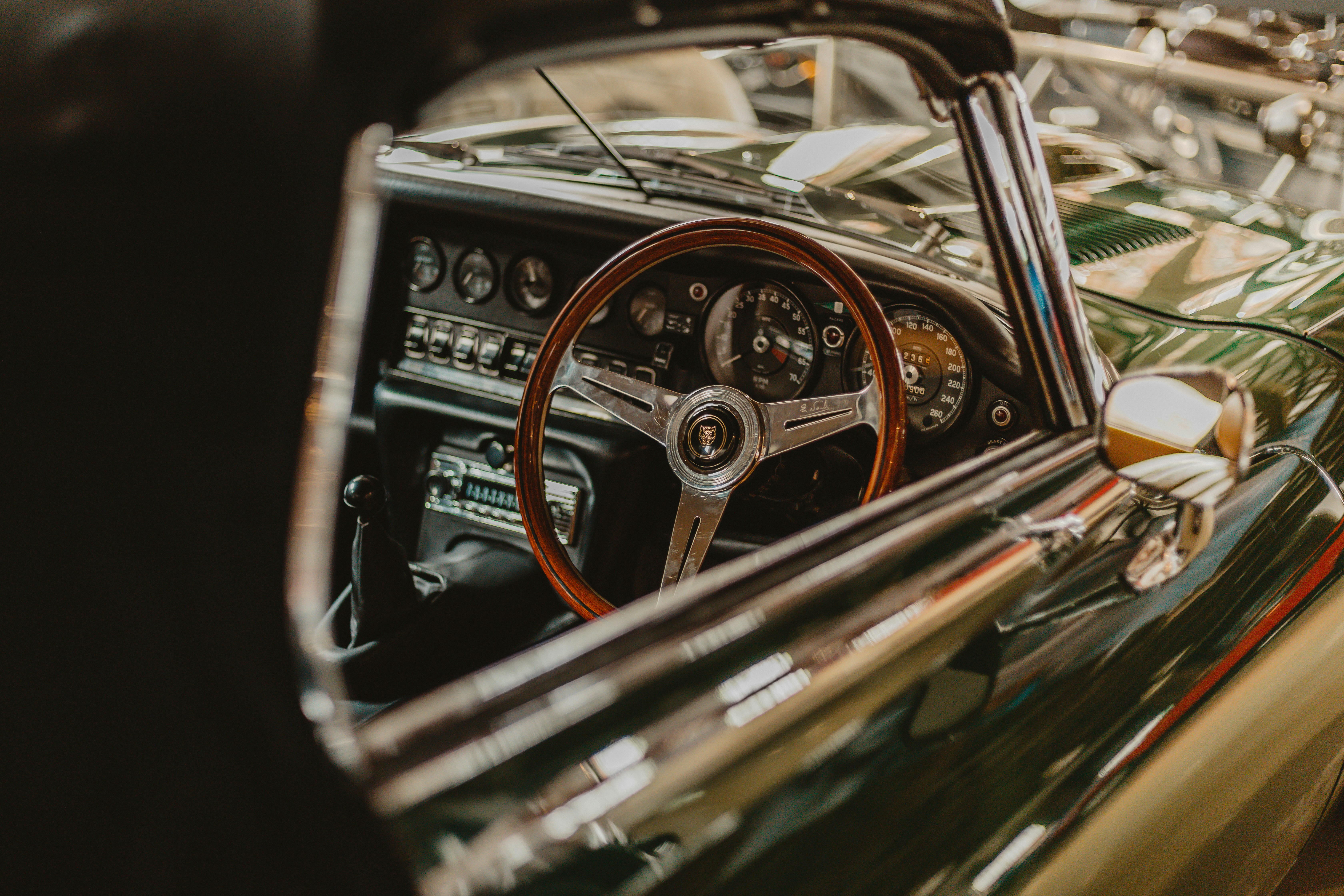 Vintage car interior showcasing a wooden steering wheel and classic dashboard instruments. A glimpse into automotive history.