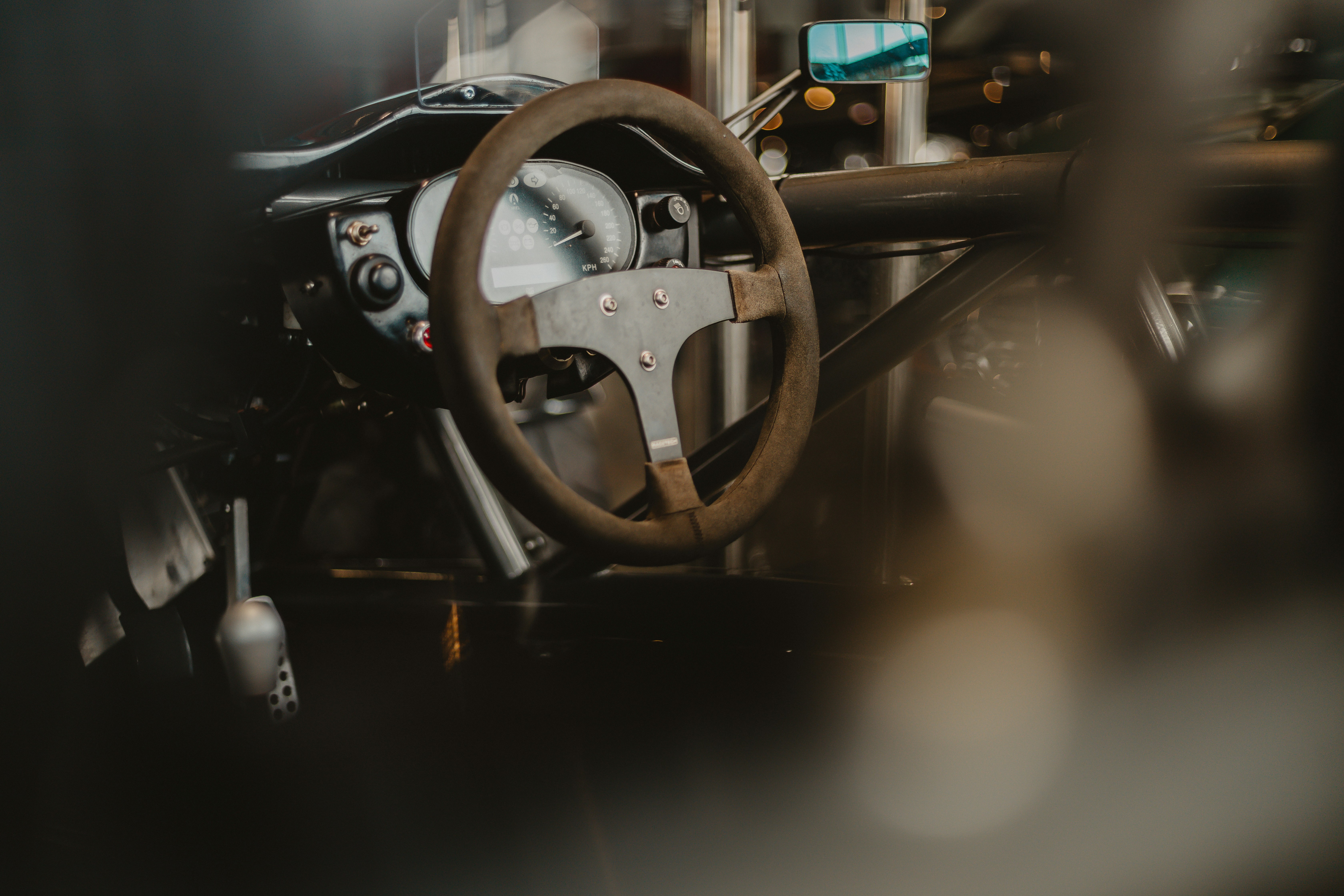 Close-up of a racing car's steering wheel and dashboard, showcasing the intricate details and design elements. The scene conveys the thrill of motorsport engineering.