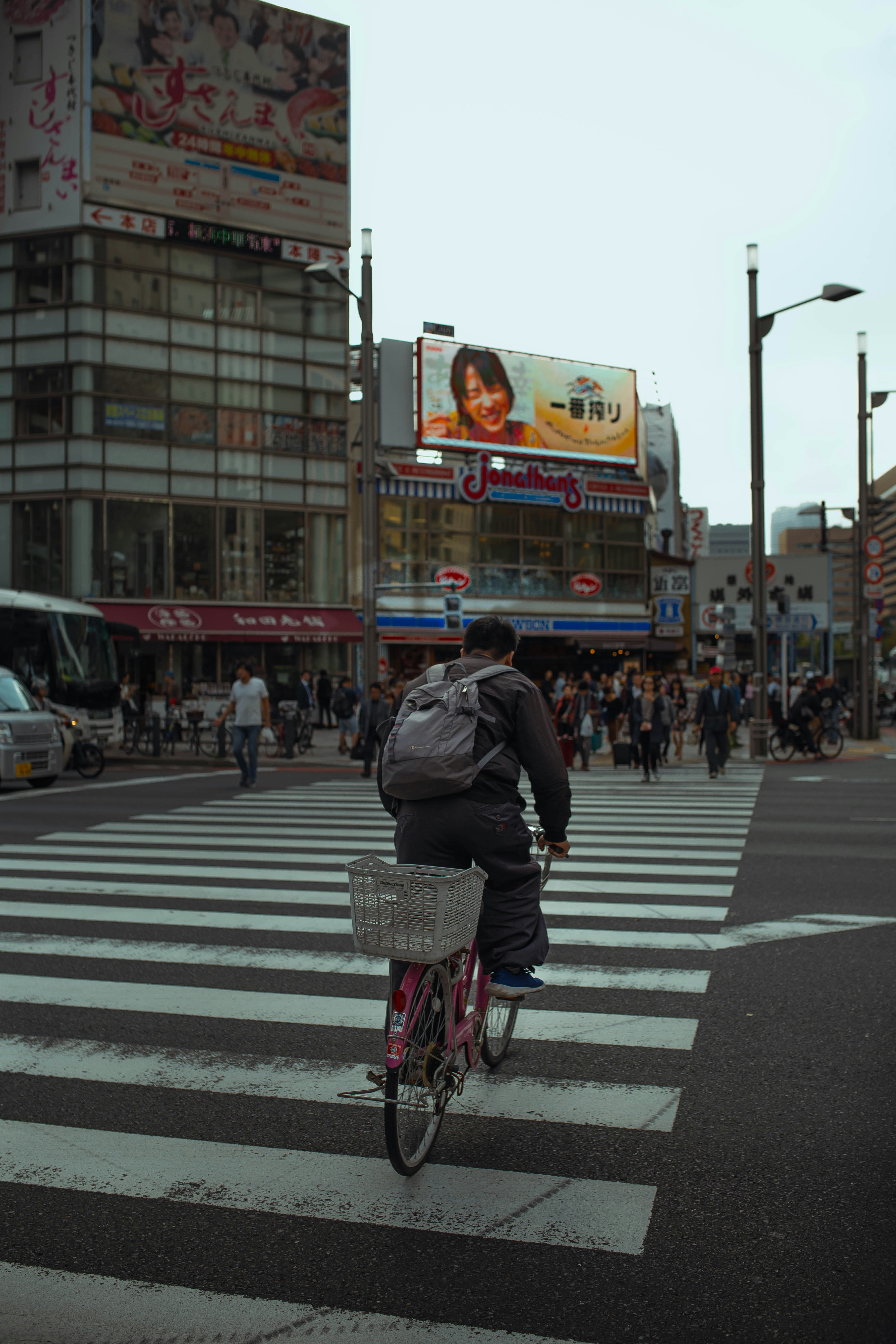Crosswalk Cadence: Backpacked Cyclist Navigates a Neon City Corridor