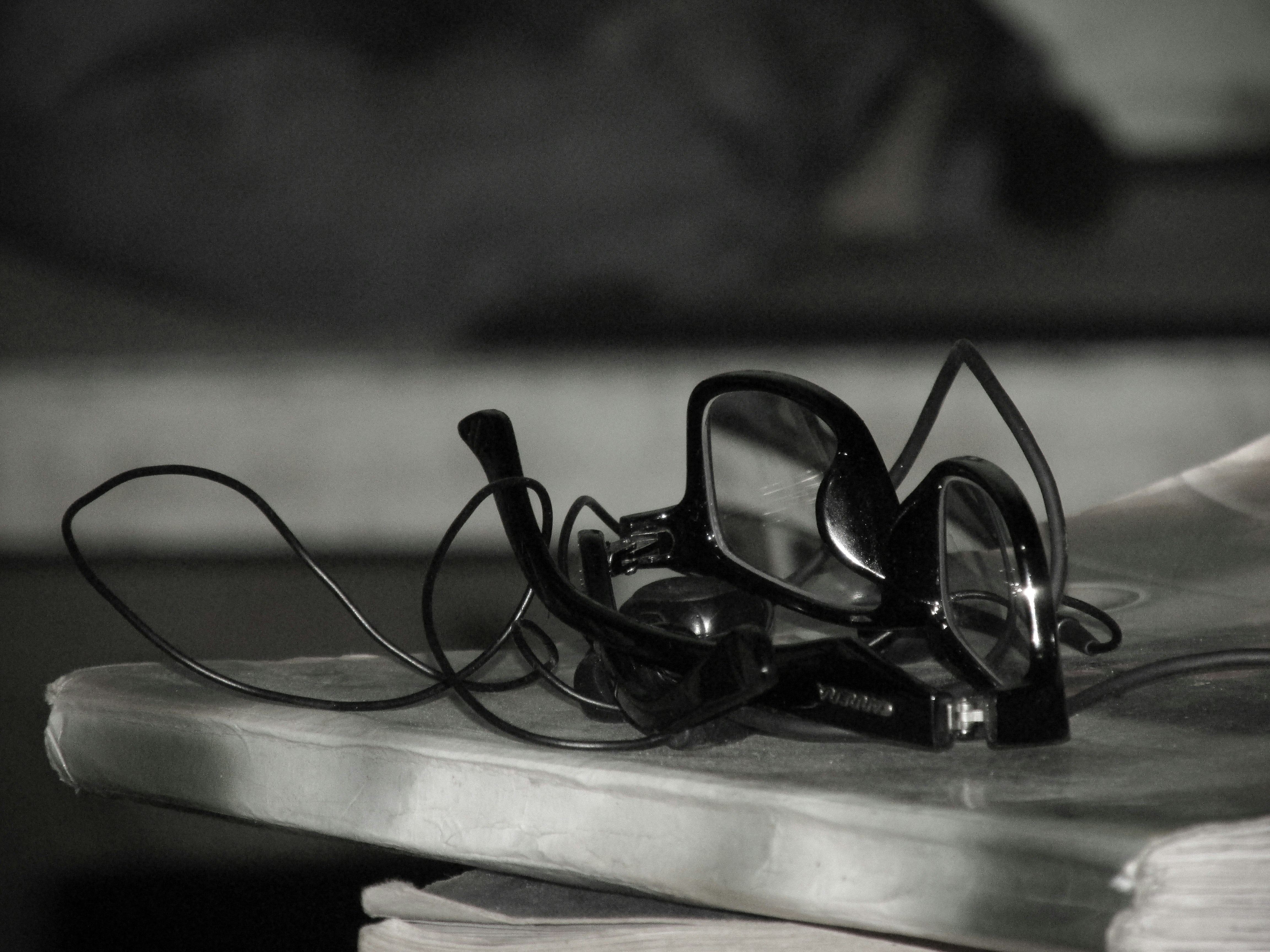 Black glasses resting on a stack of papers with a blurred background, emphasizing the theme of vision and clarity.