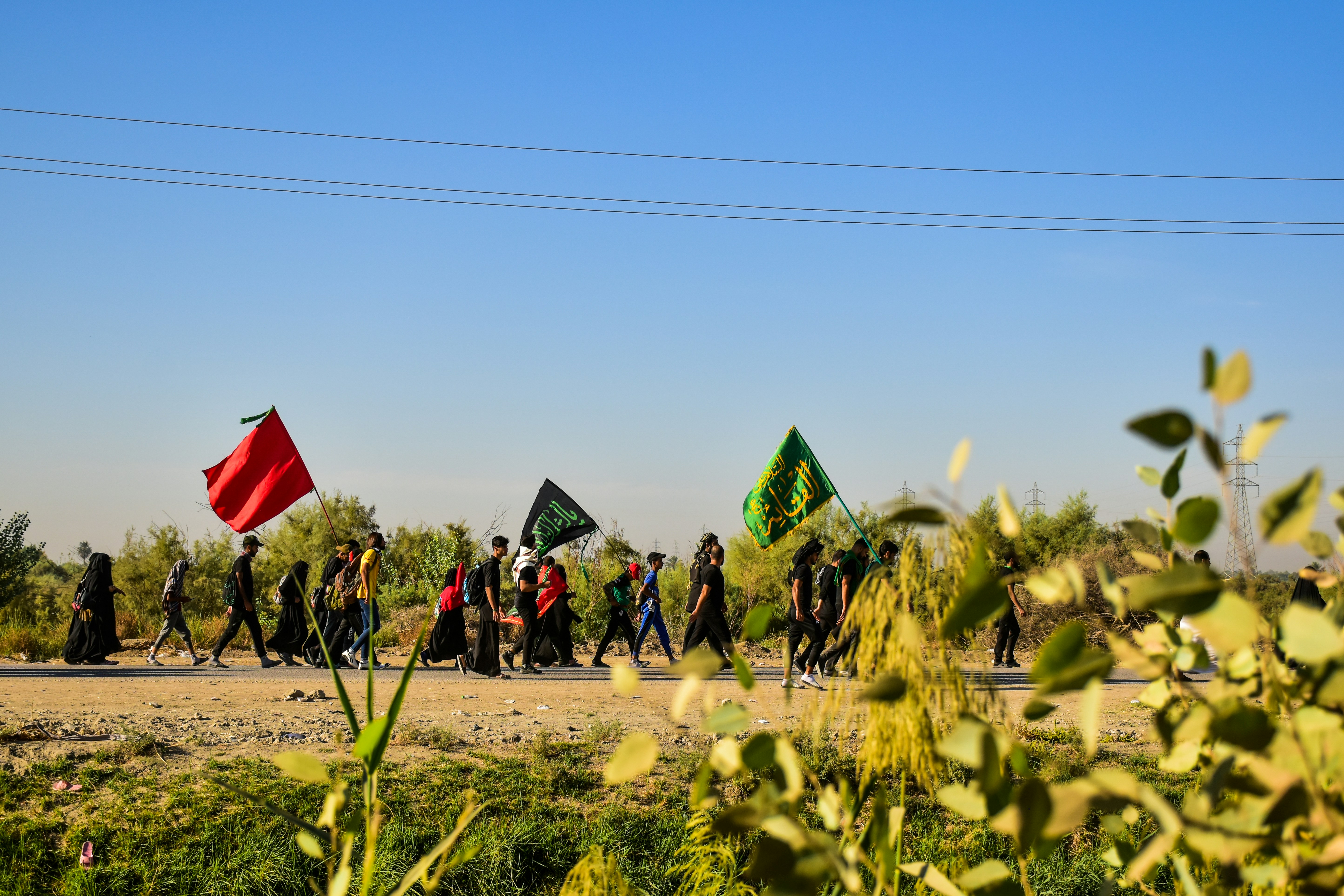 People in green and red flags on brown field under blue sky during ...