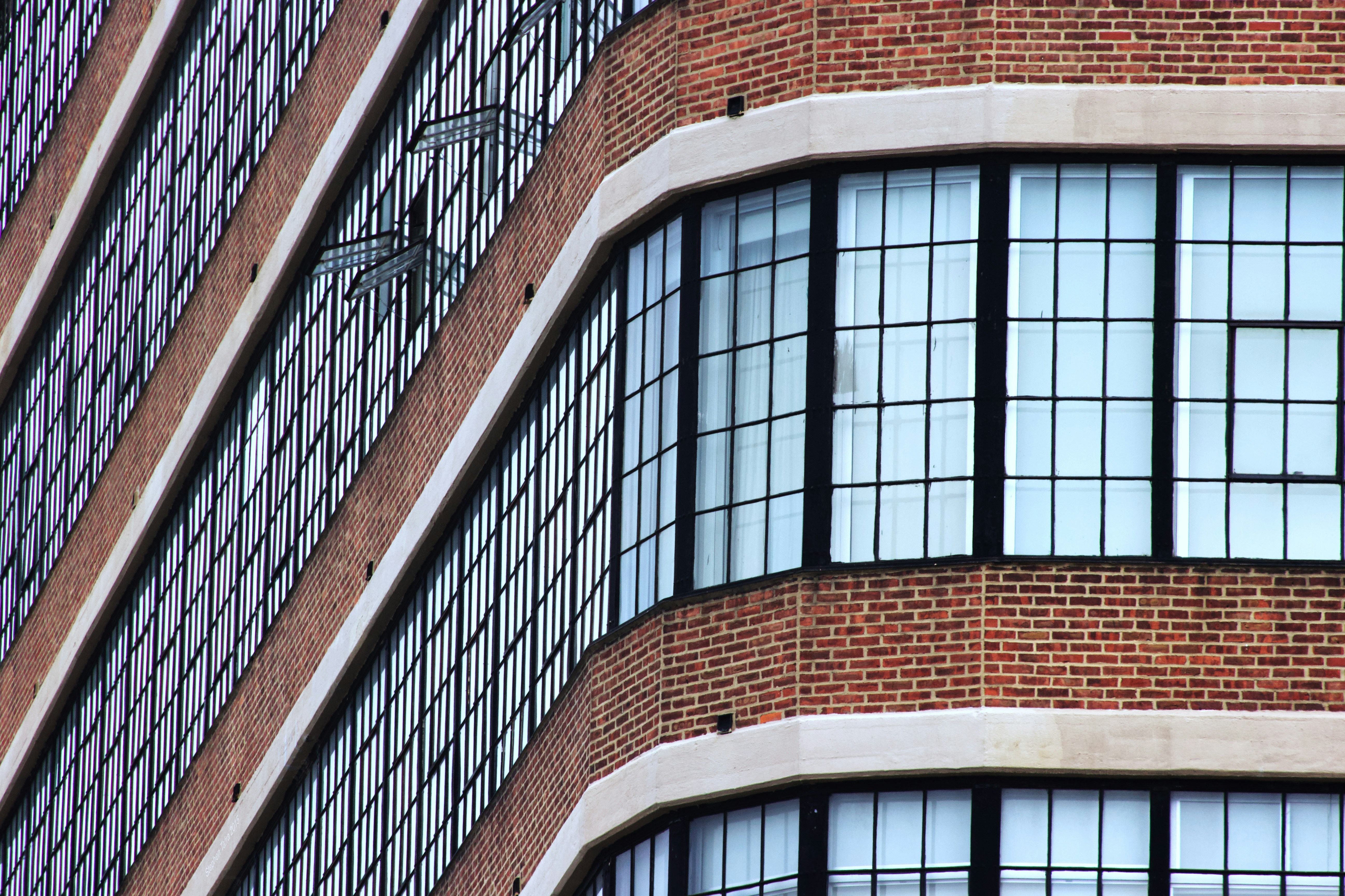 Curved brick building facade with large grid windows.