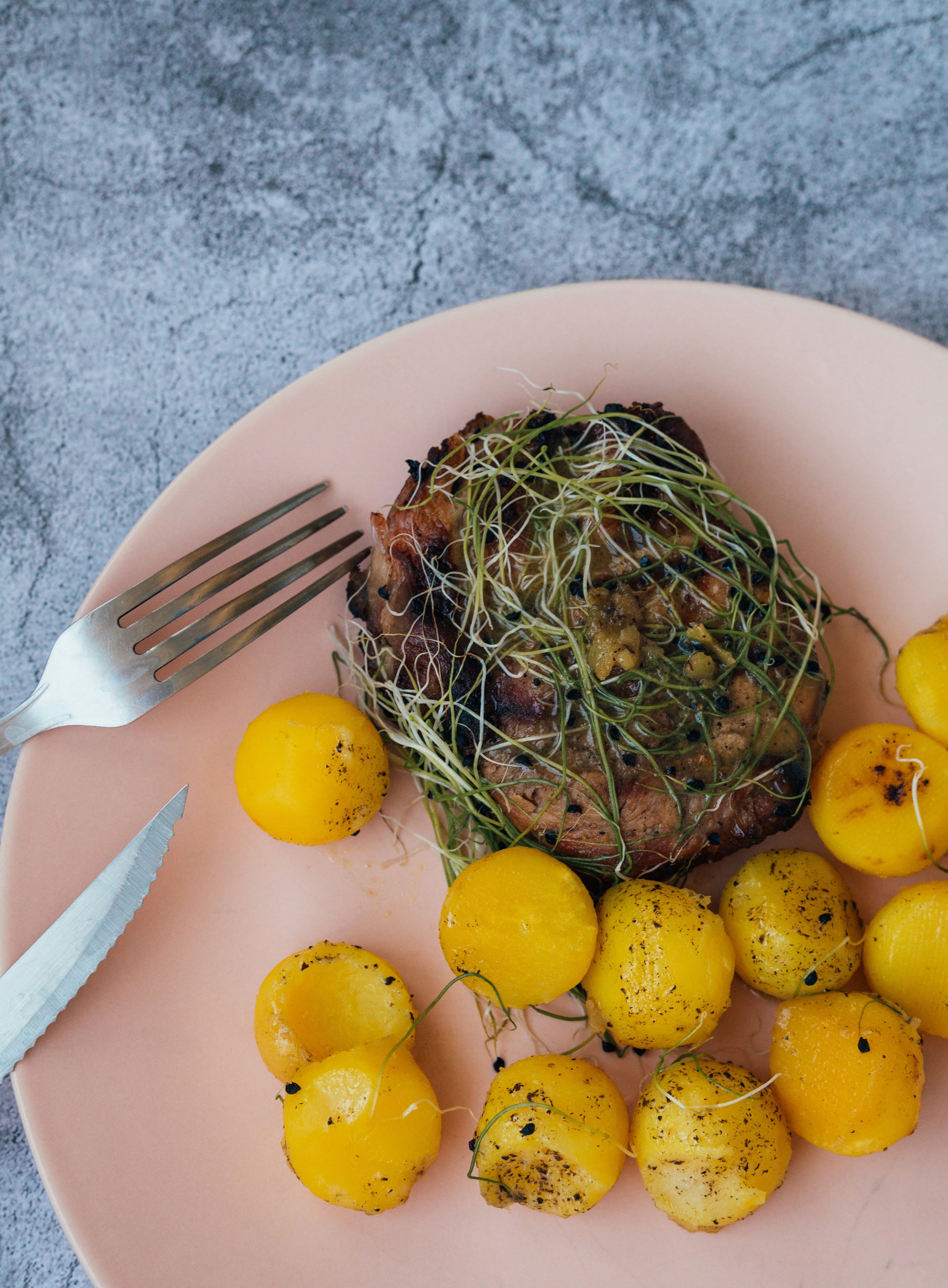 Herb-Crusted Roast Nest: Greens Crown on a Blush Plate with Golden Potatoes