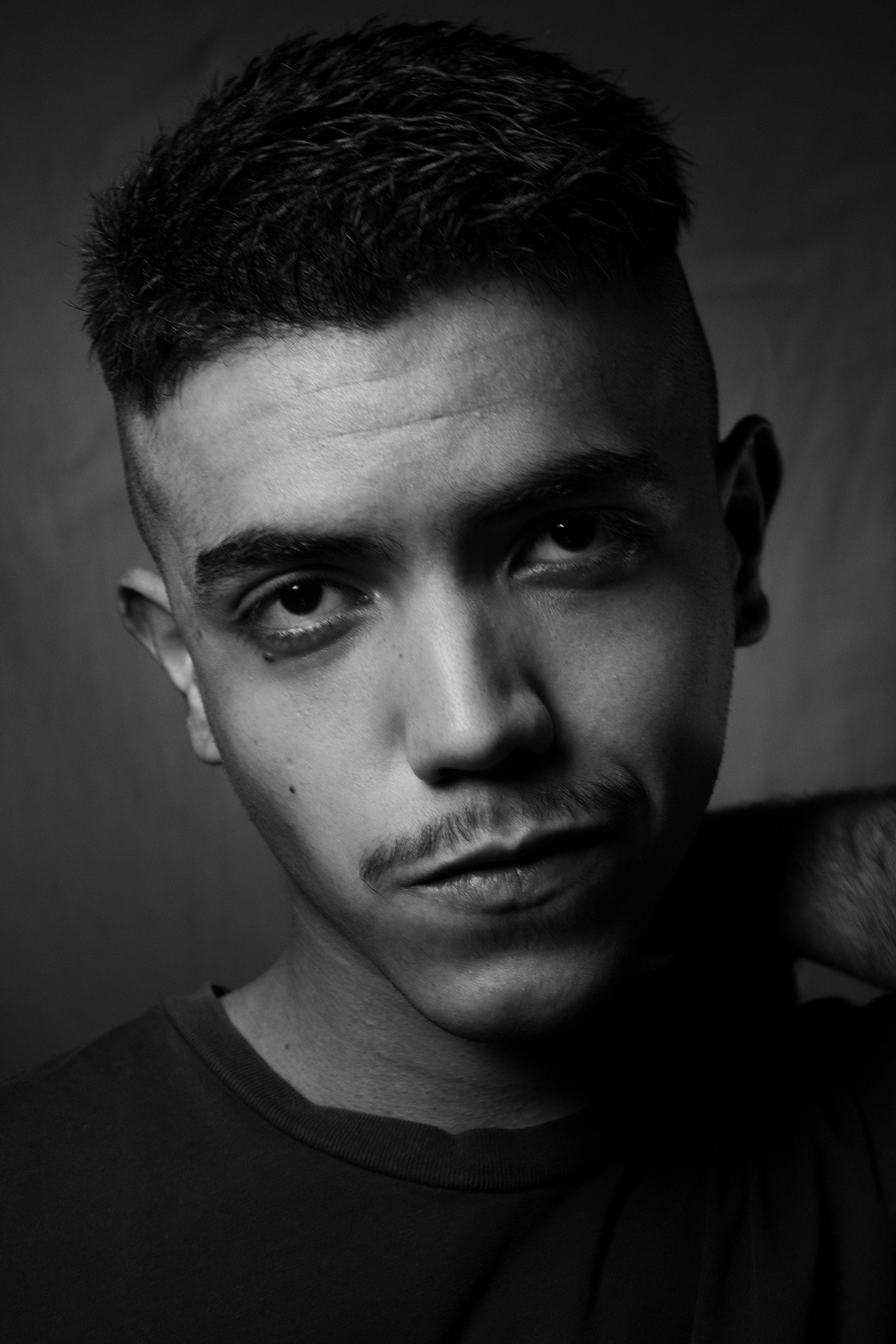 Close-up black and white portrait of a man with a contemplative expression.