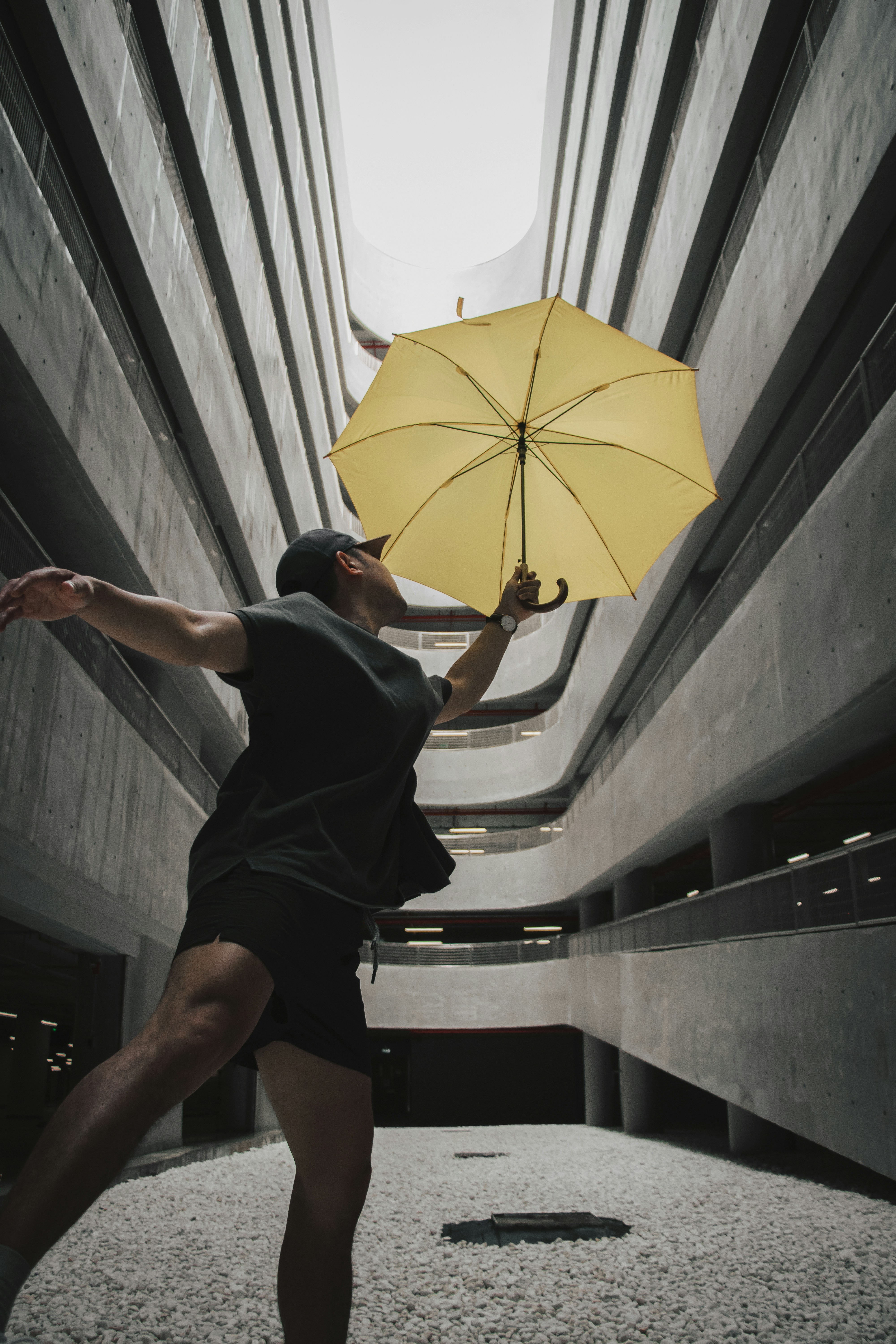 A man holding a yellow umbrella in a building photo – Free Person Image ...