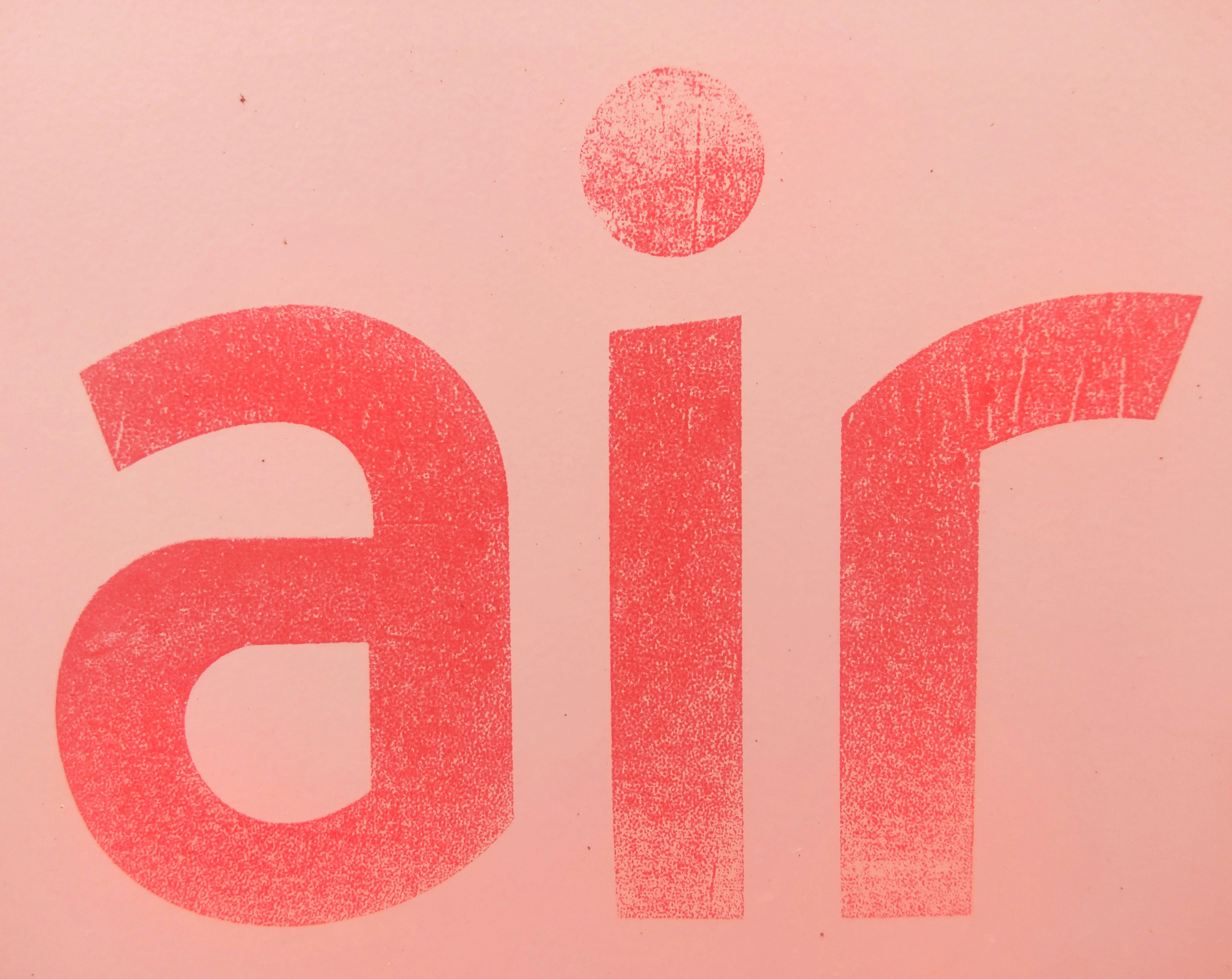 Bold typography featuring the word 'air' with a circular accent, set against a soft pink background.