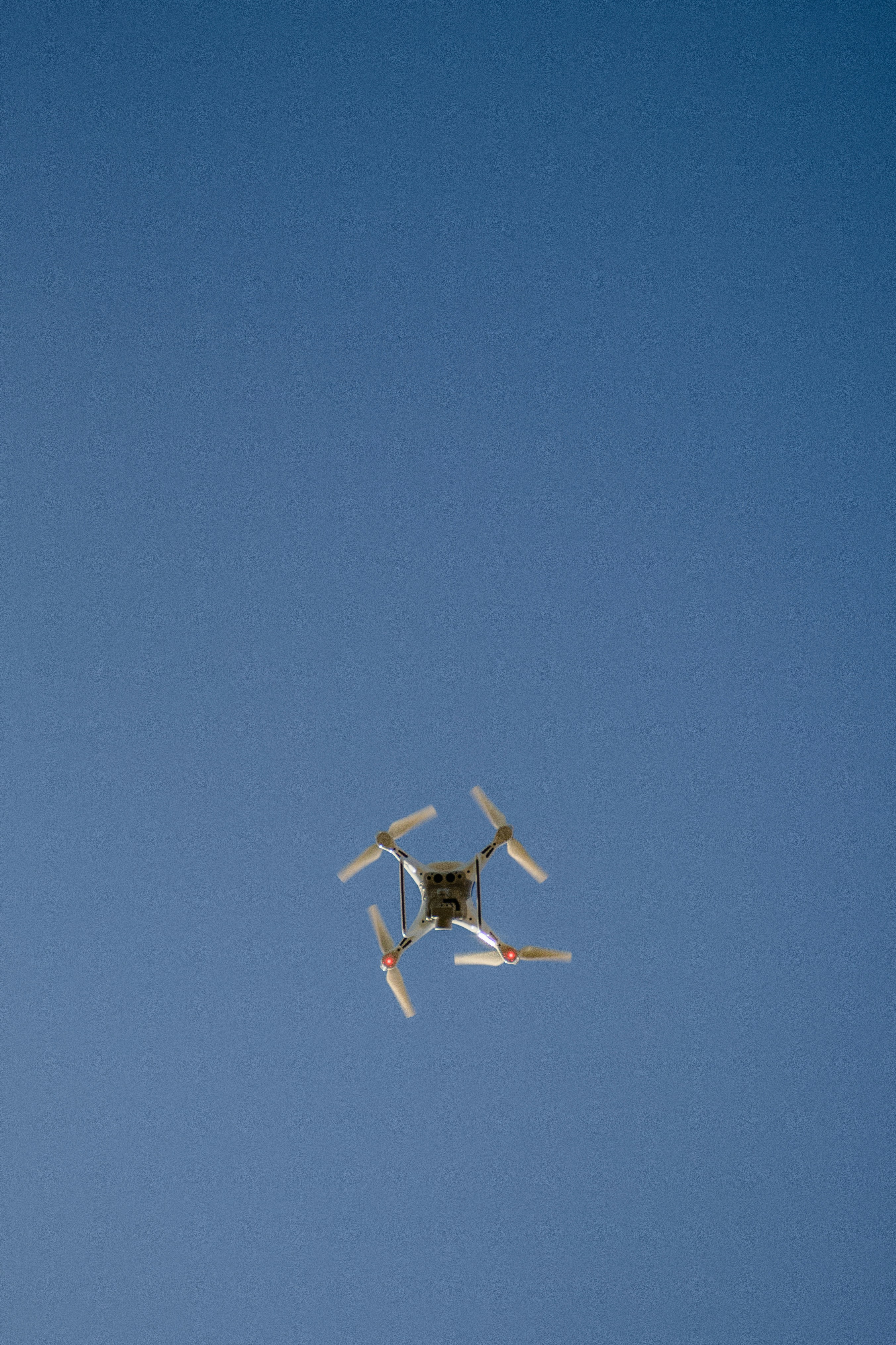 white and black drone flying under blue sky during daytime