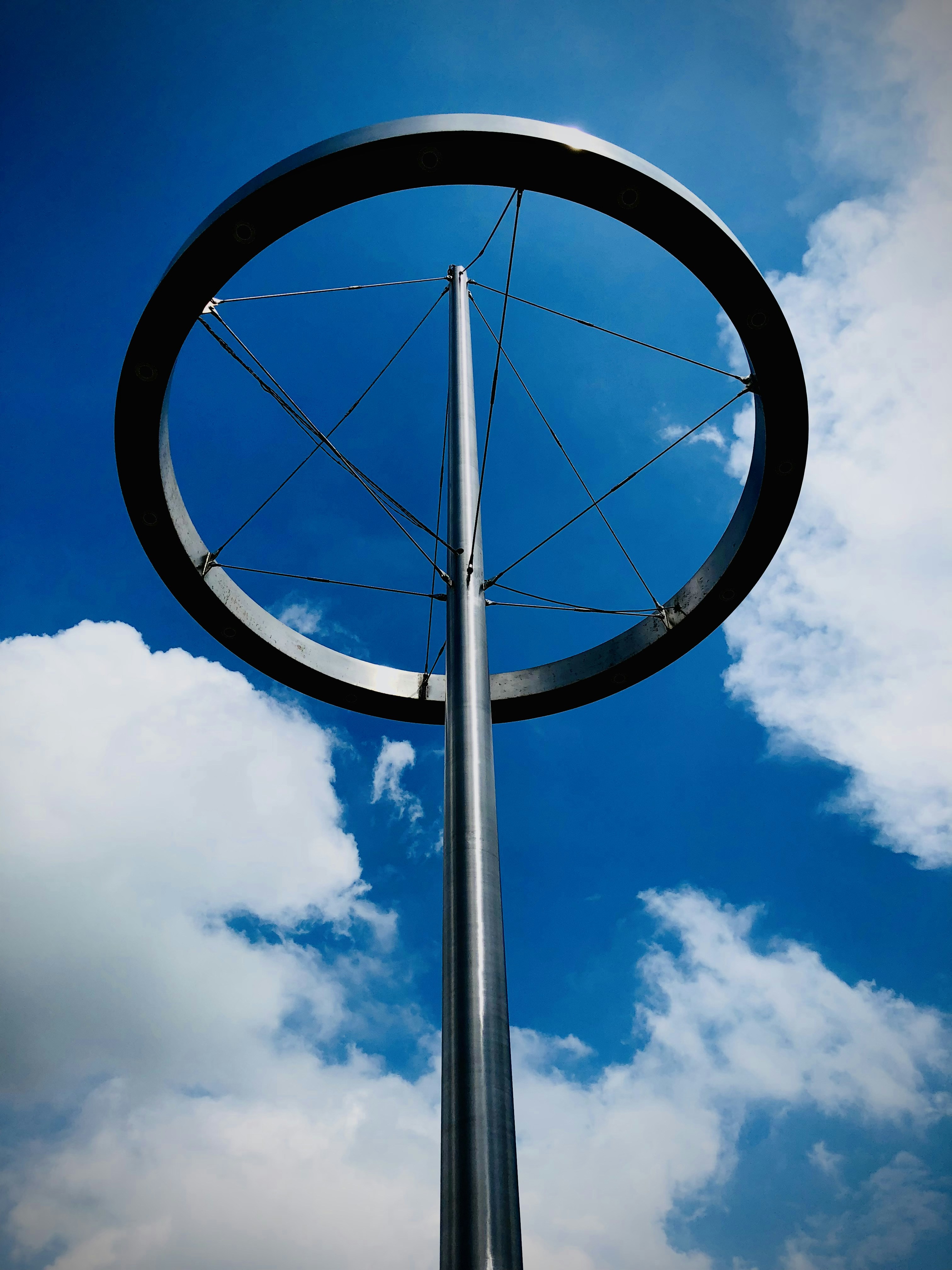 Ringed Sentinel: A Steel Halo Rising Into a Clear Sky