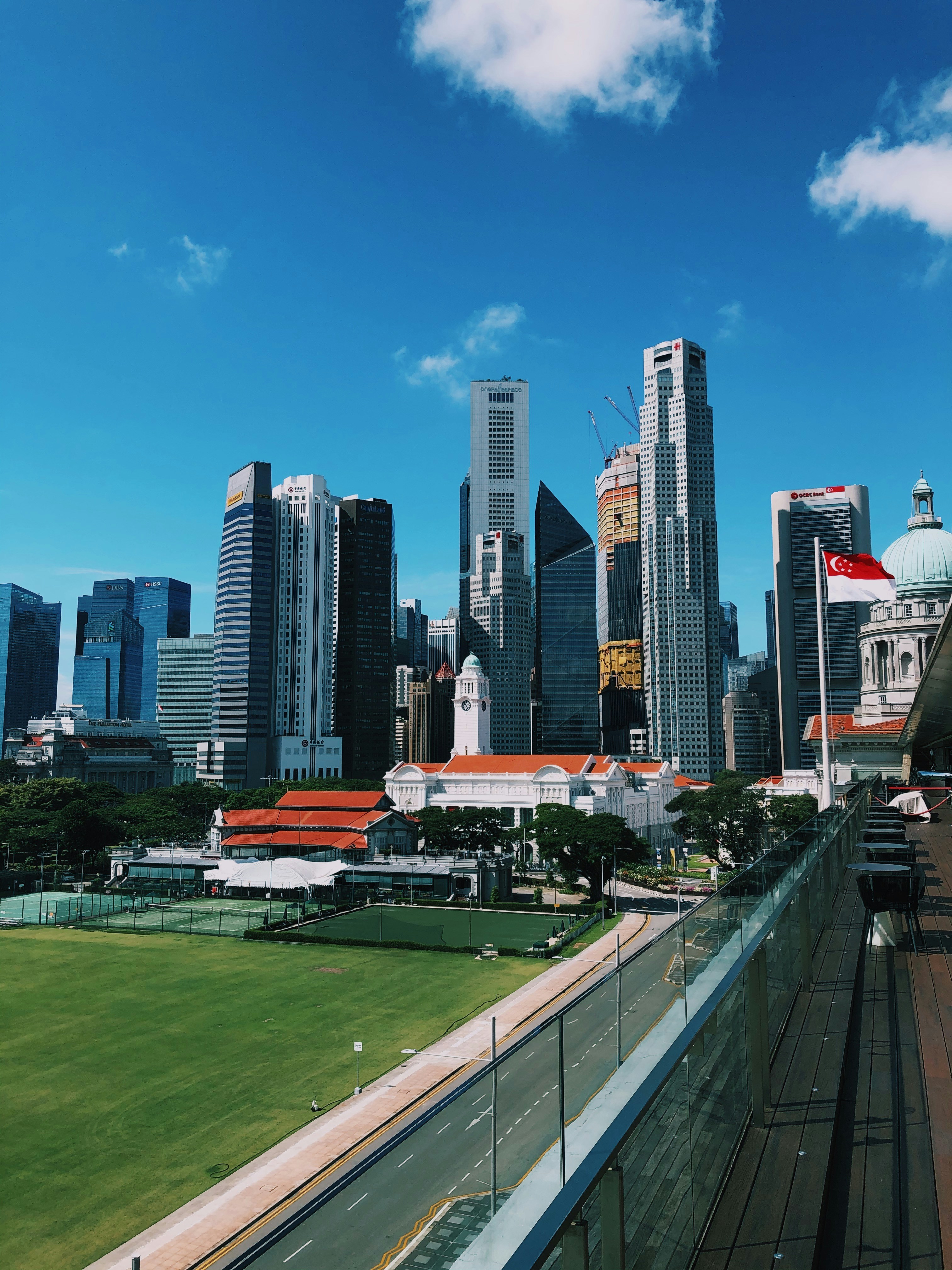 A panoramic view of Singapore's skyline showcasing a blend of modern skyscrapers and historical buildings under a clear blue sky.