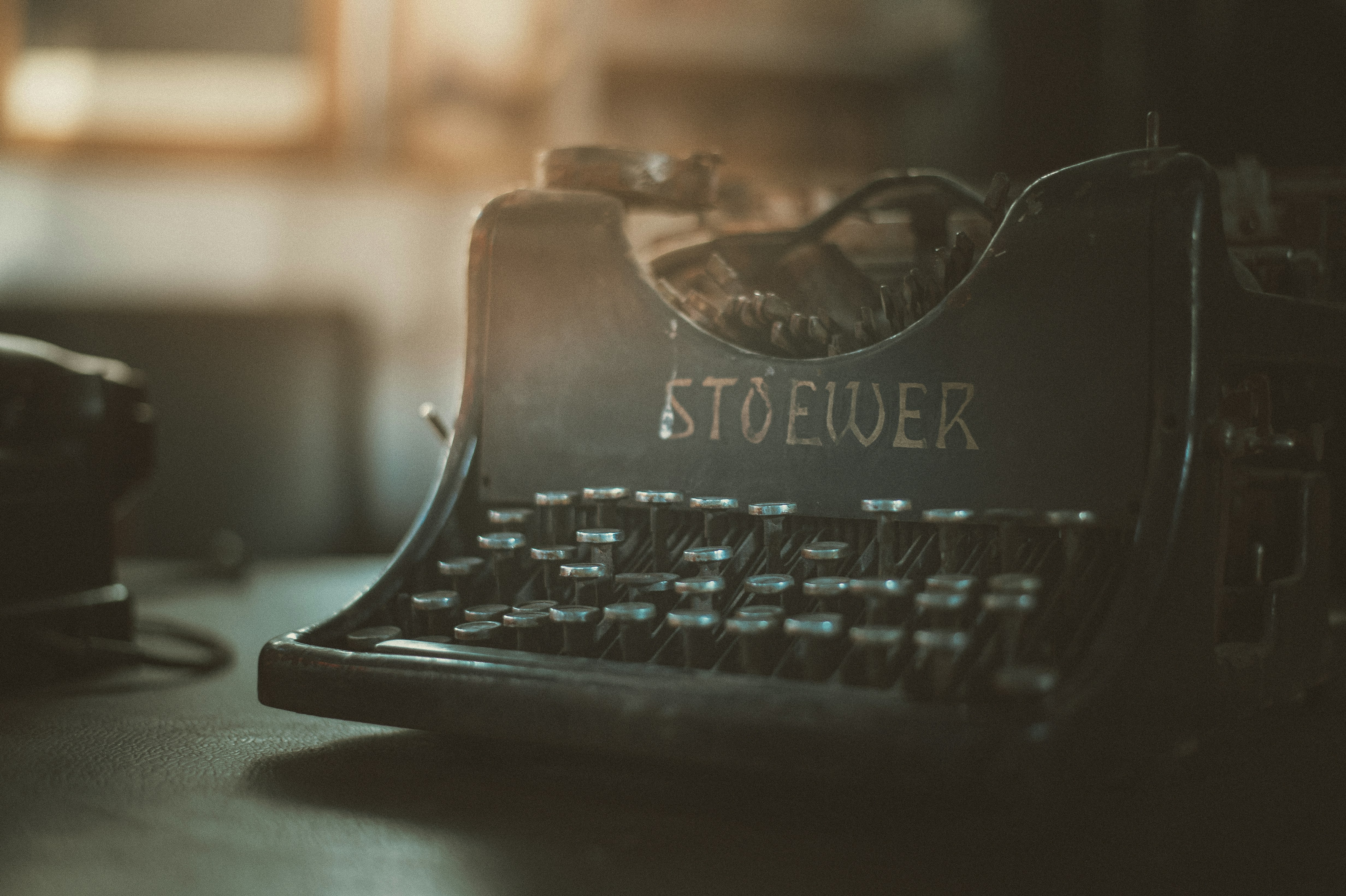 Close-up of an antique typewriter with faded keys and a warm, nostalgic ambiance. The intricate details highlight its craftsmanship.