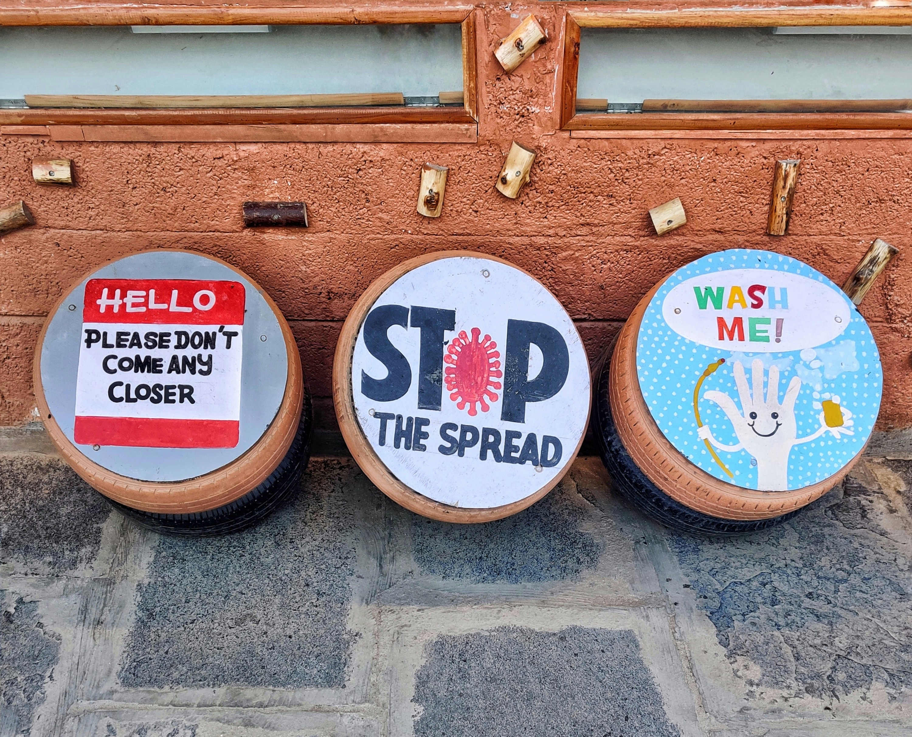 Three Circular Stools with Printed Messages on a Street Corner