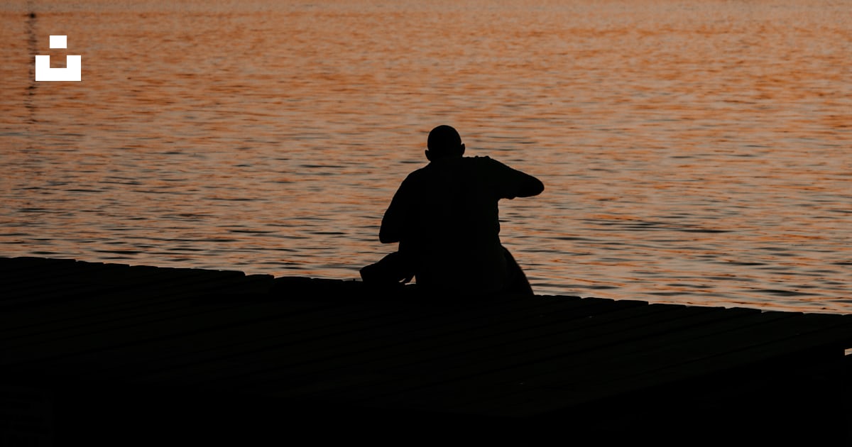 Foto Silueta De La Persona Sentada En El Muelle Durante La Puesta De