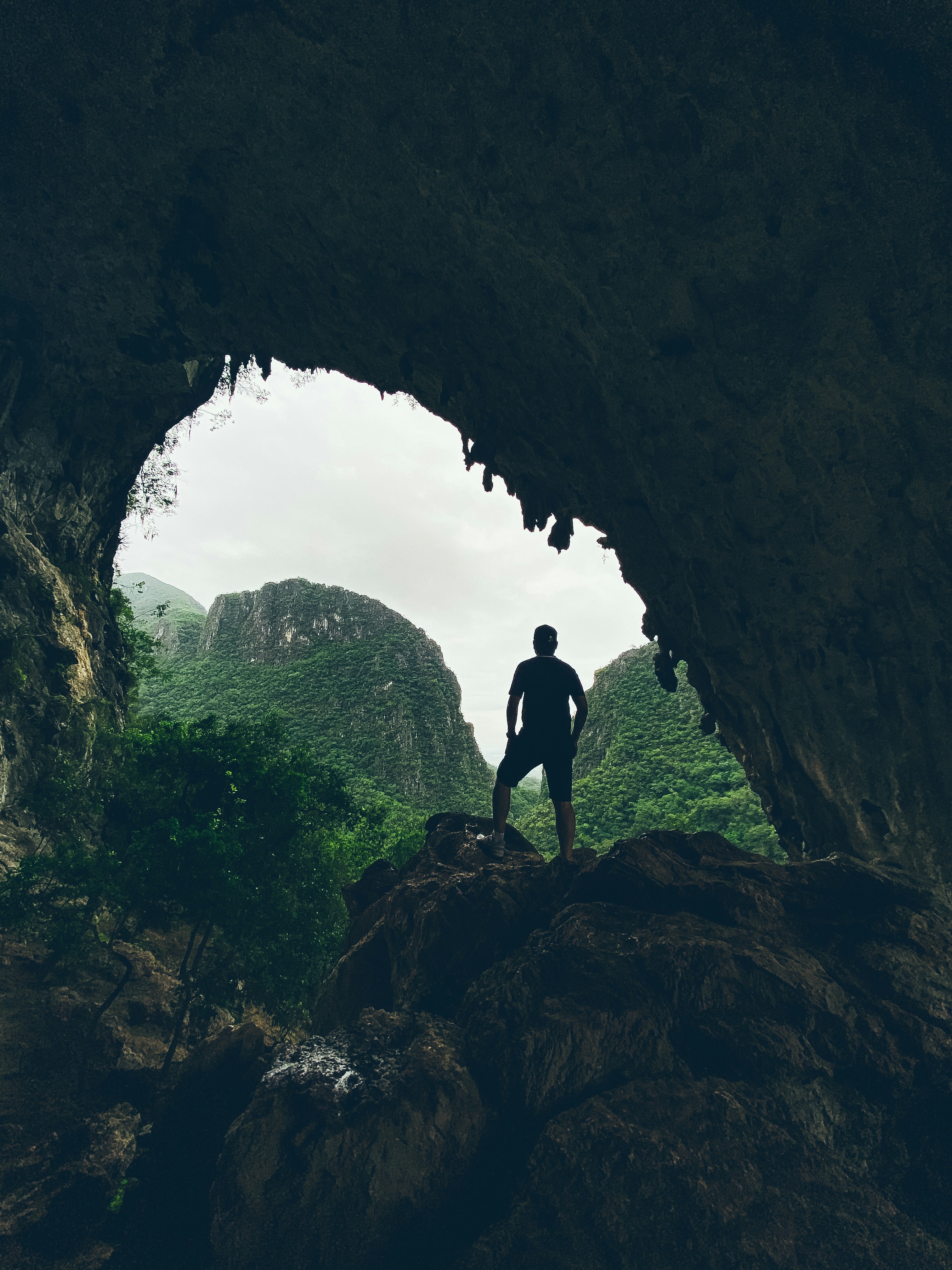 Man in black shirt standing on rock formation during daytime photo ...