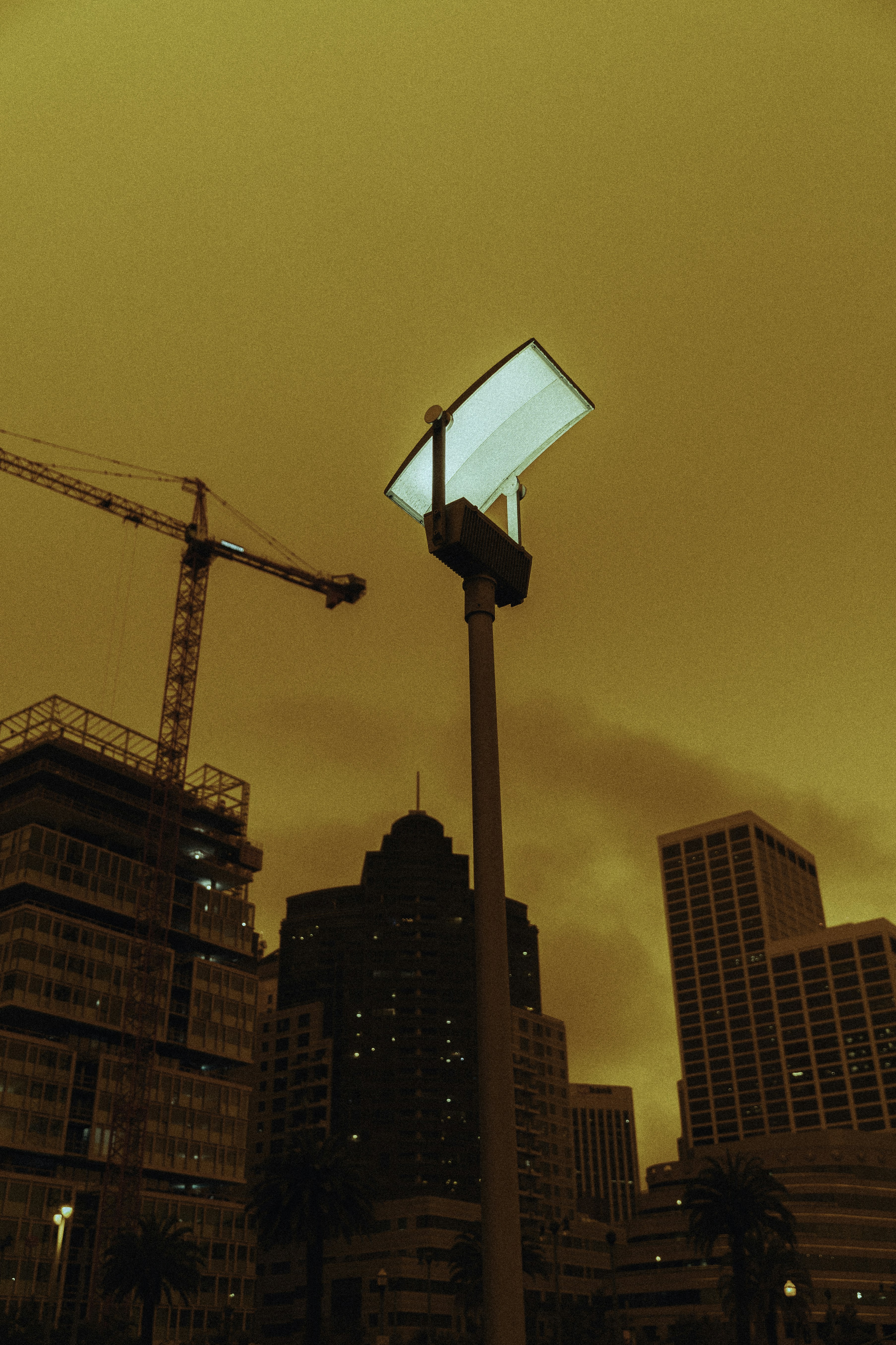 Urban Floodlights: A Towering Lamp Over a Crescent of Skyscrapers