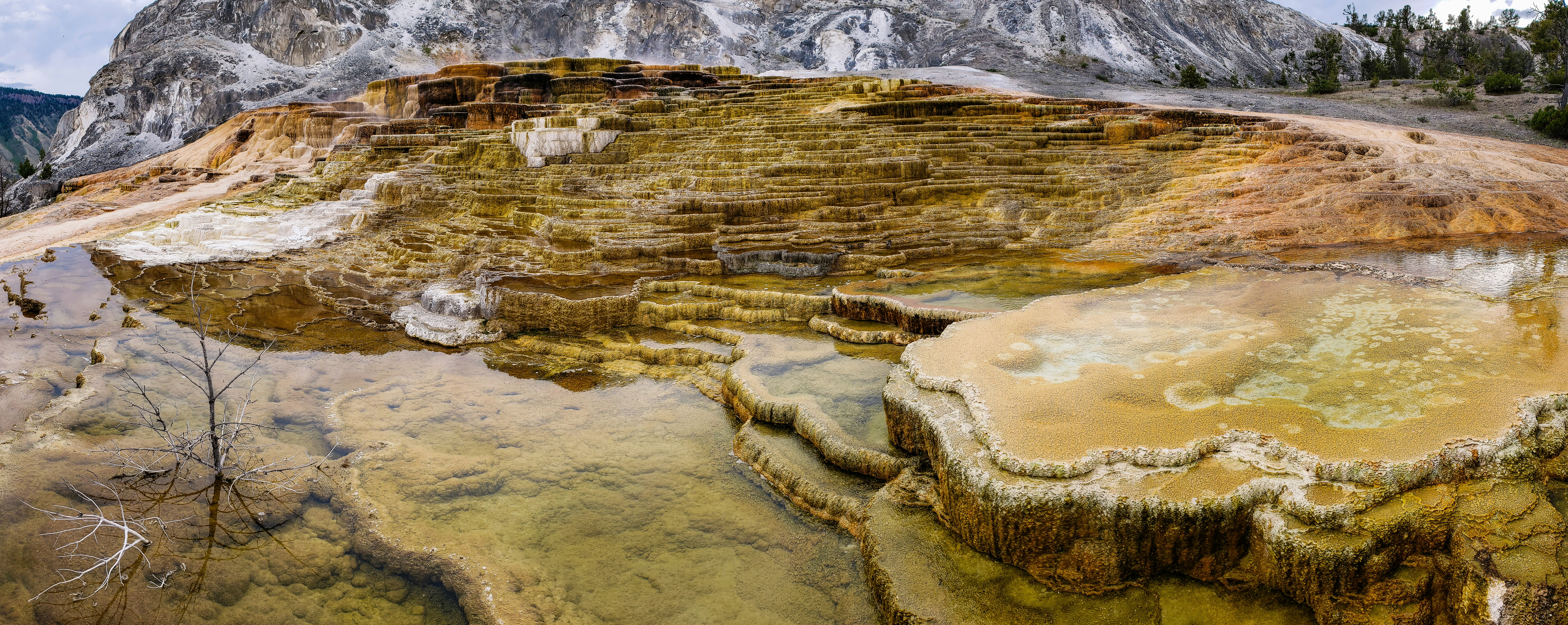 Terraced mineral pools beneath rugged pinnacles
