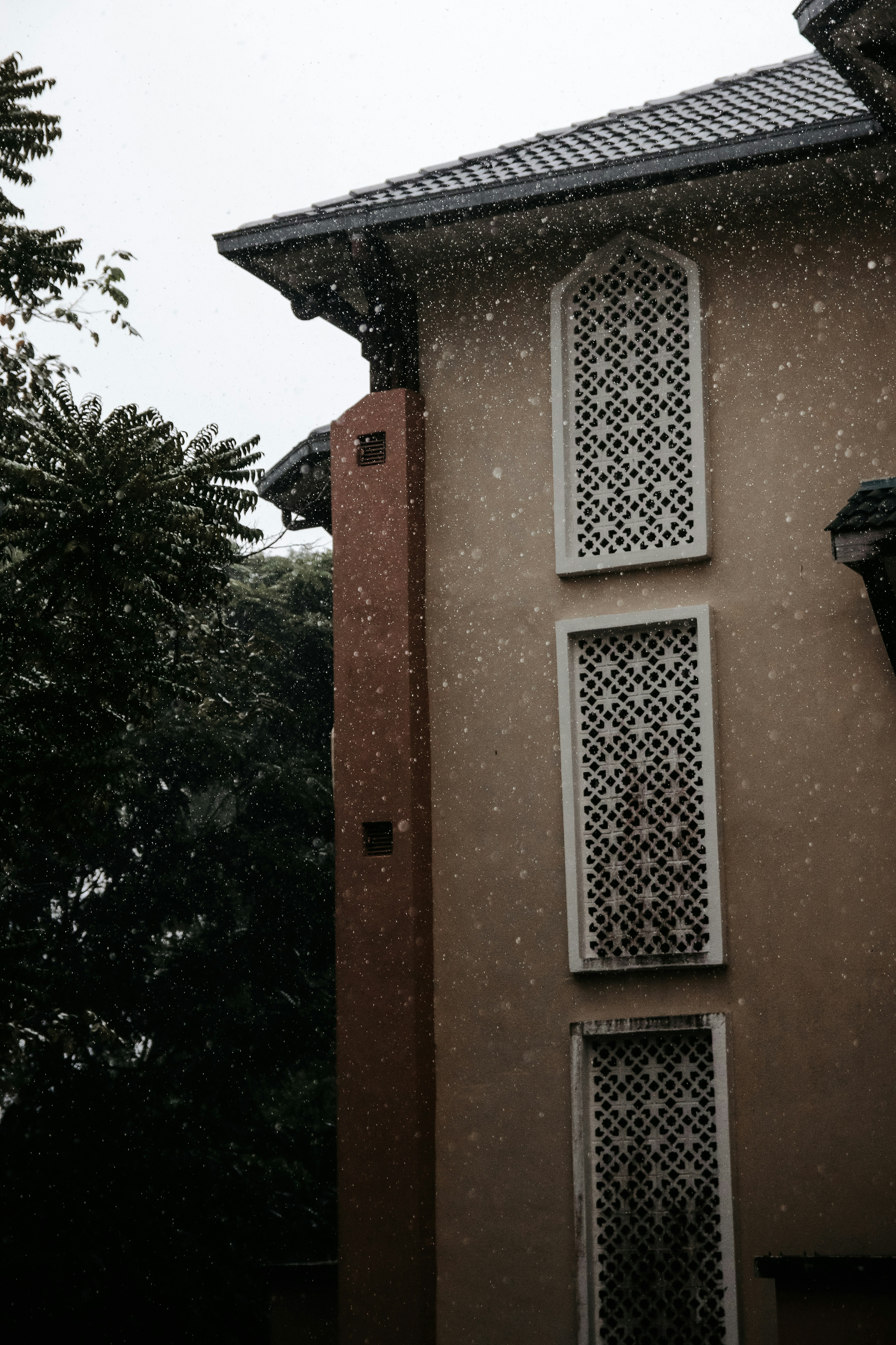 Snowfall drapes a lattice-faced facade