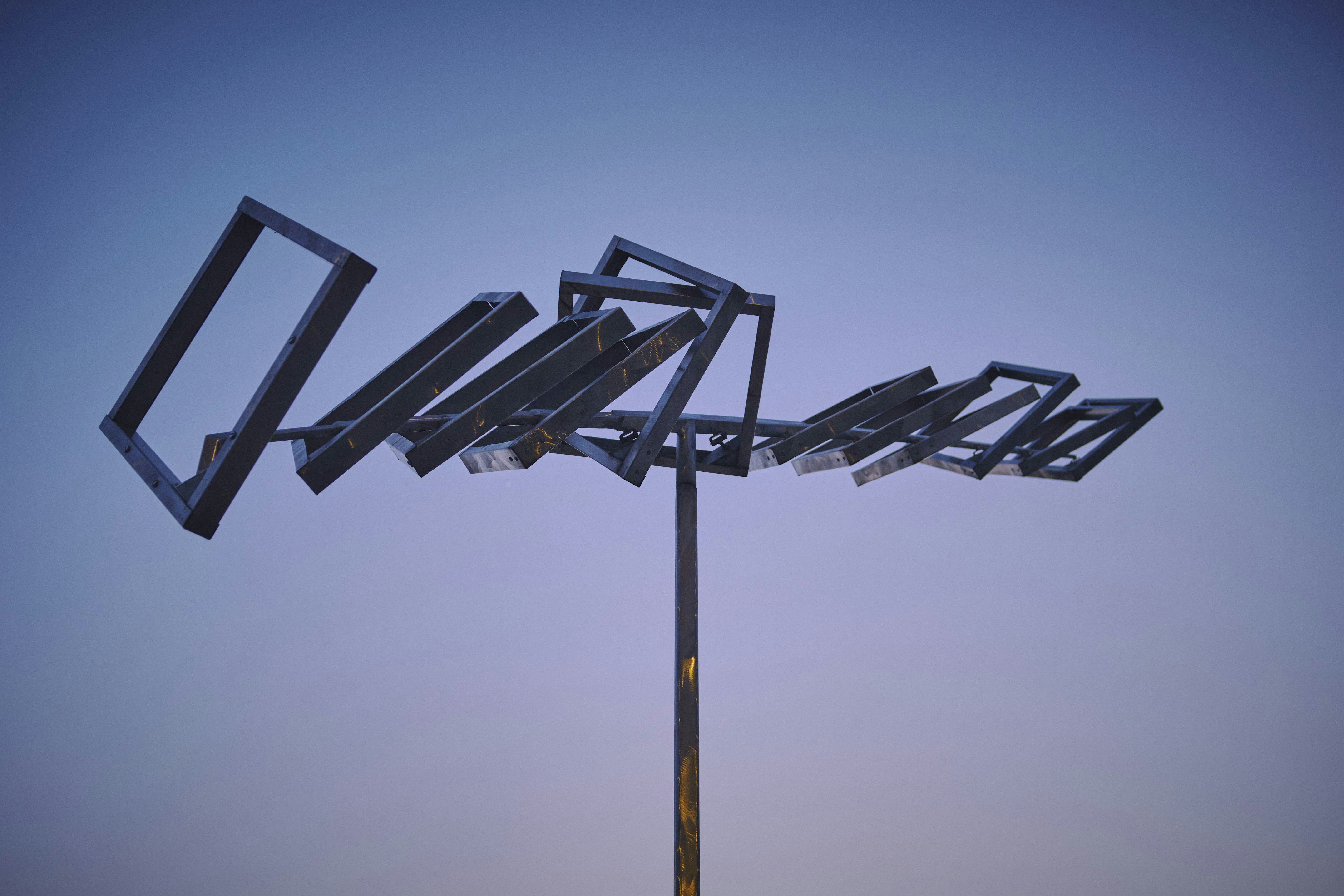 Angular Glyphs on a Lone Mast Under a Gradient Dusk