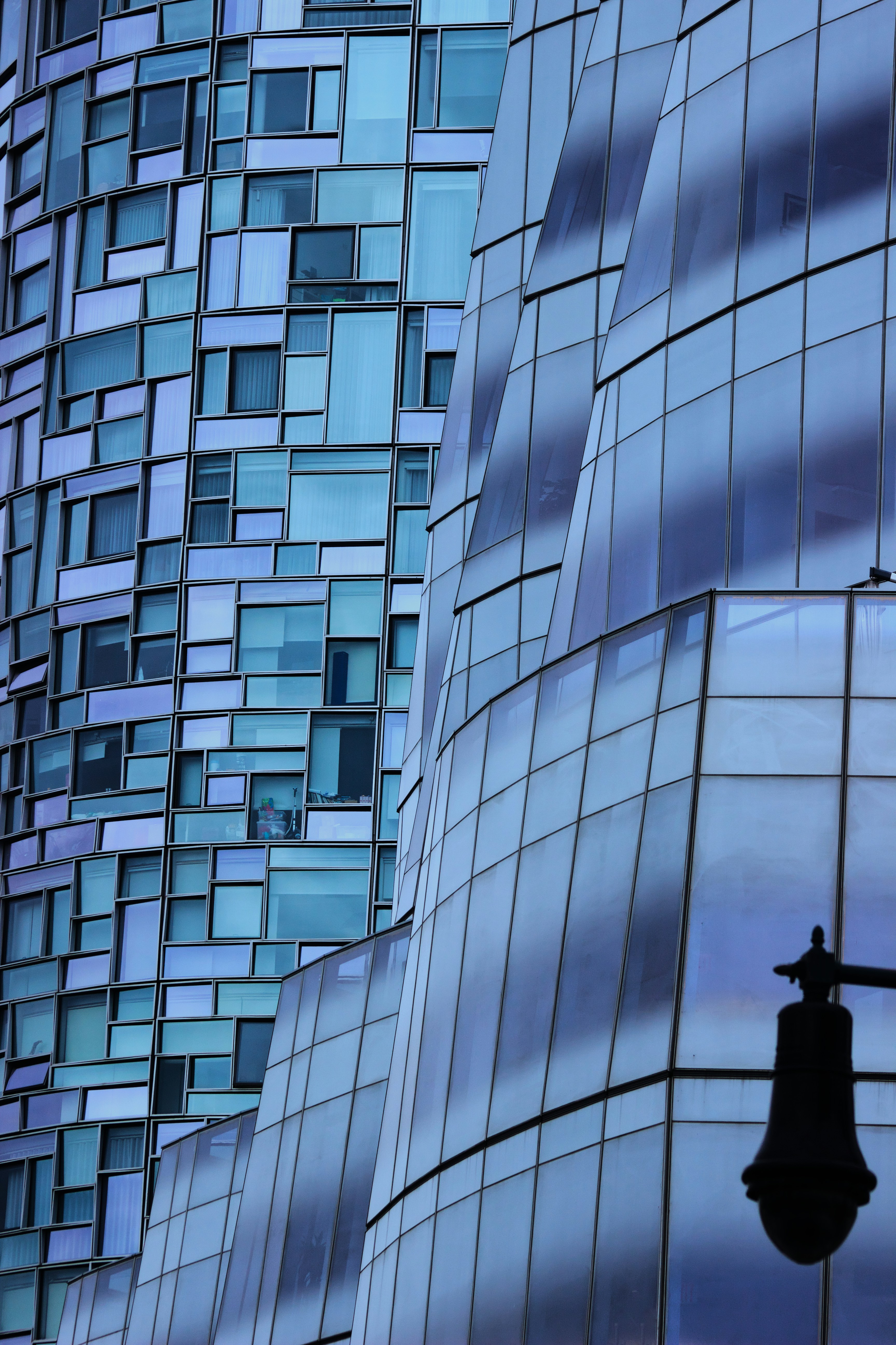 man in black jacket standing in front of glass building