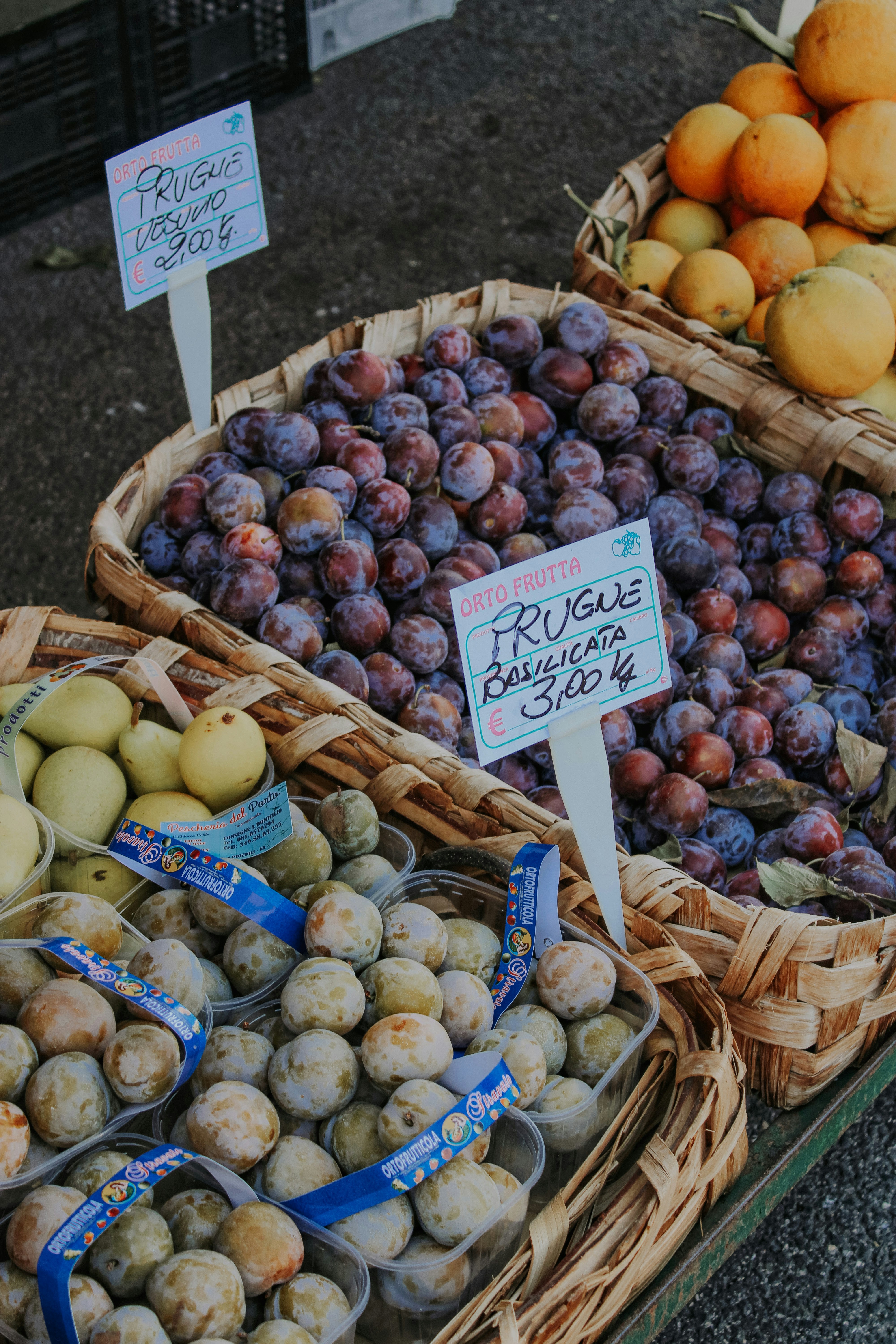 Basket of Sunlit Plums and Lemons at a Market Stall