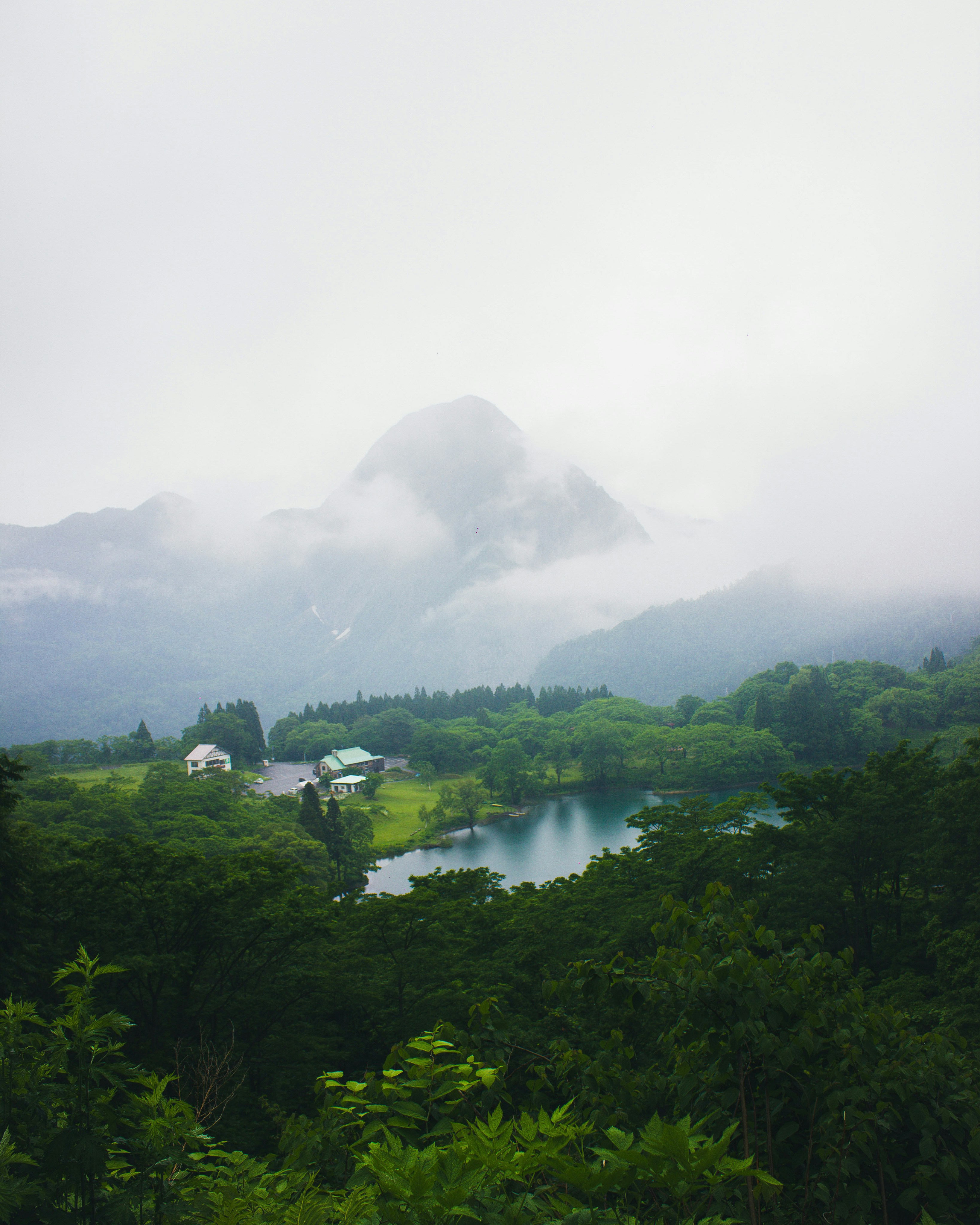 Mist-veiled Peak over a Serene Lakeside Village
