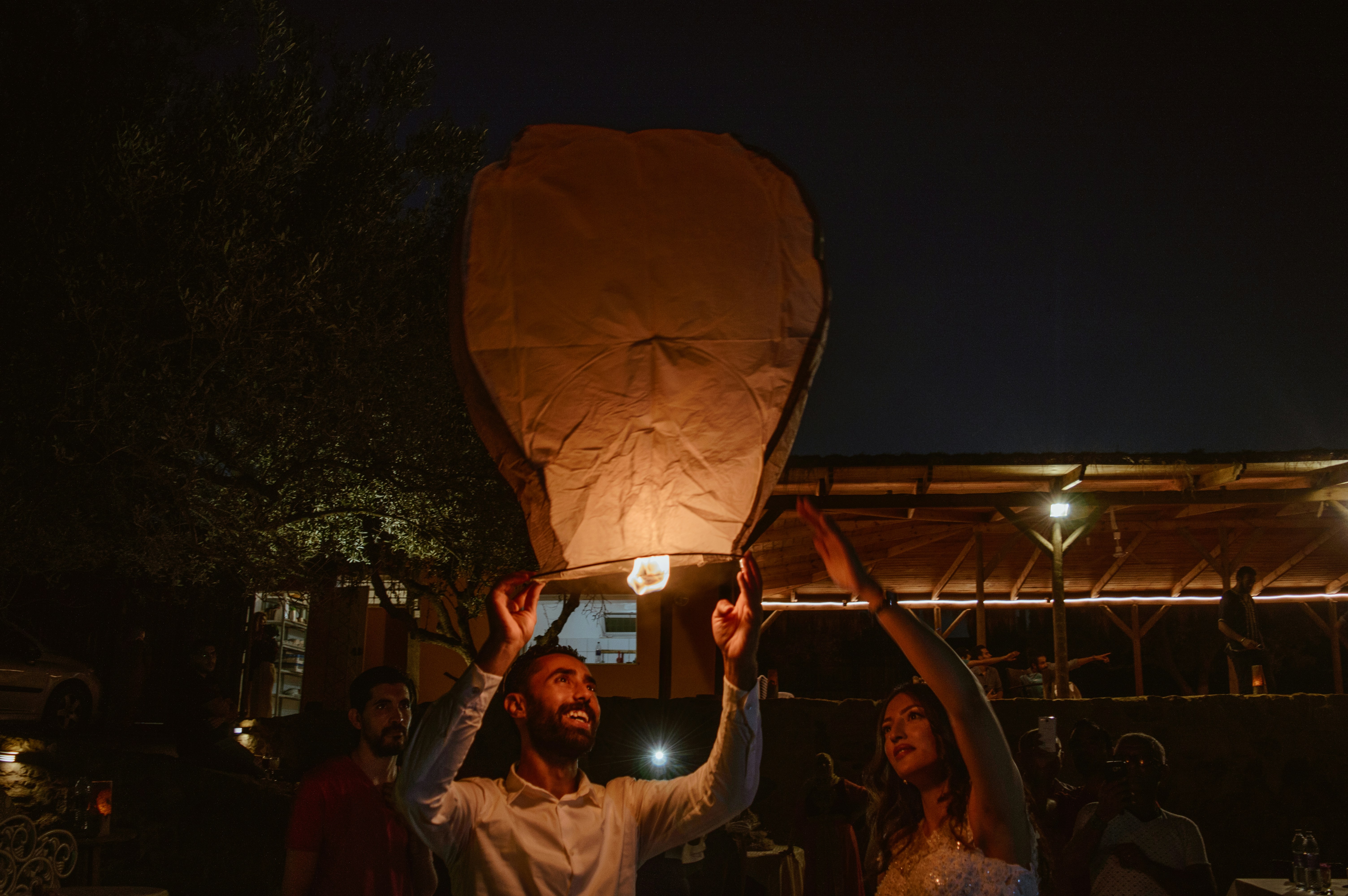 Sky Lantern Ascent: A Nighttime Wish Released Over a Cozy Outdoor Celebration