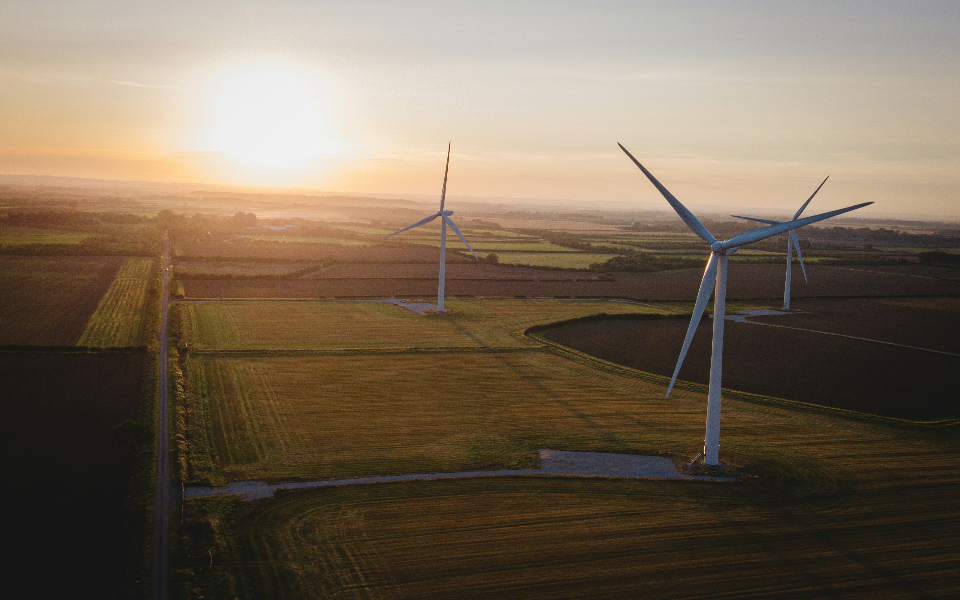 Glimmering Windfield: Sunset Over a trio of Wind Turbines