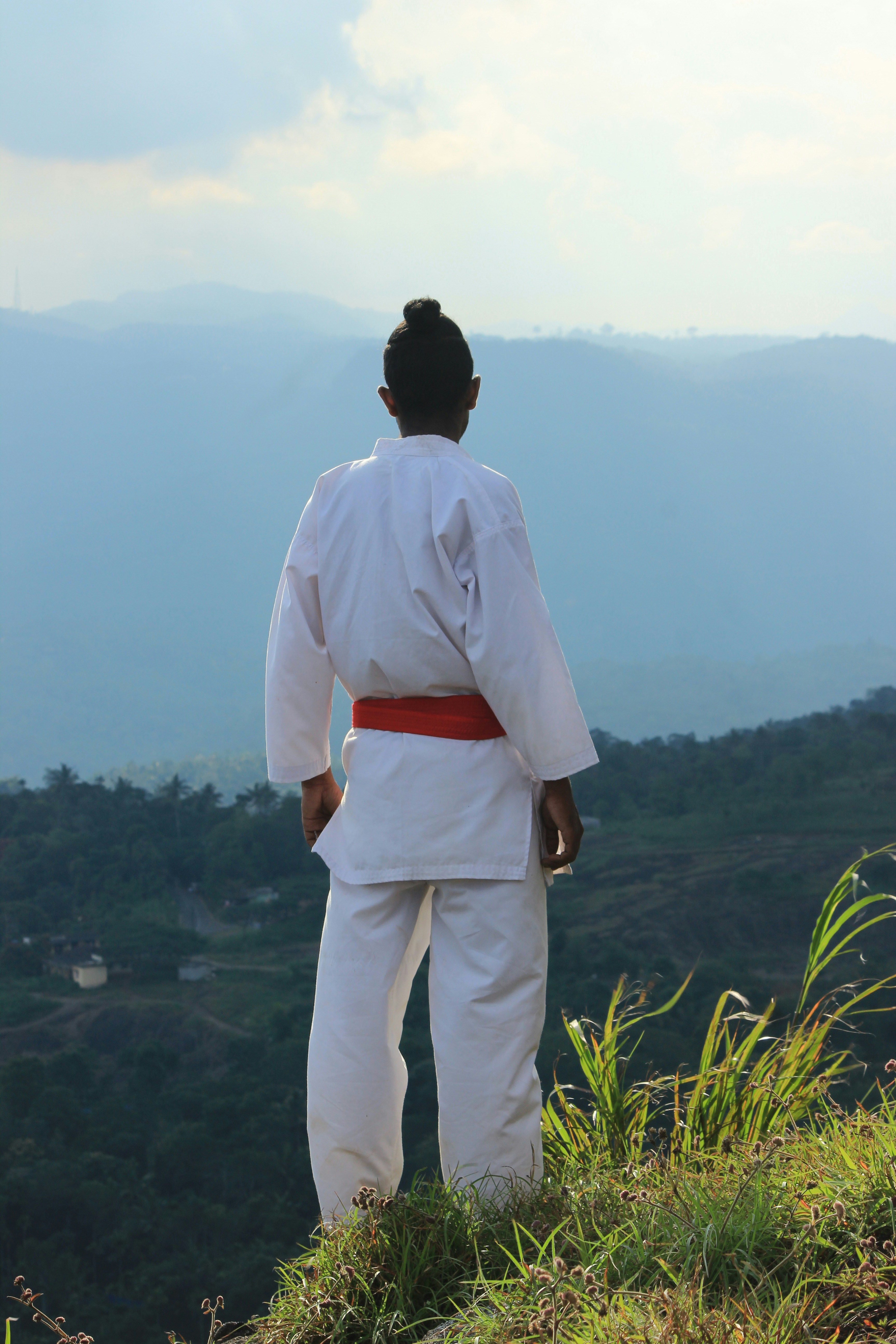 Silhouette in White: A Summit Stance Against a Serene Valley