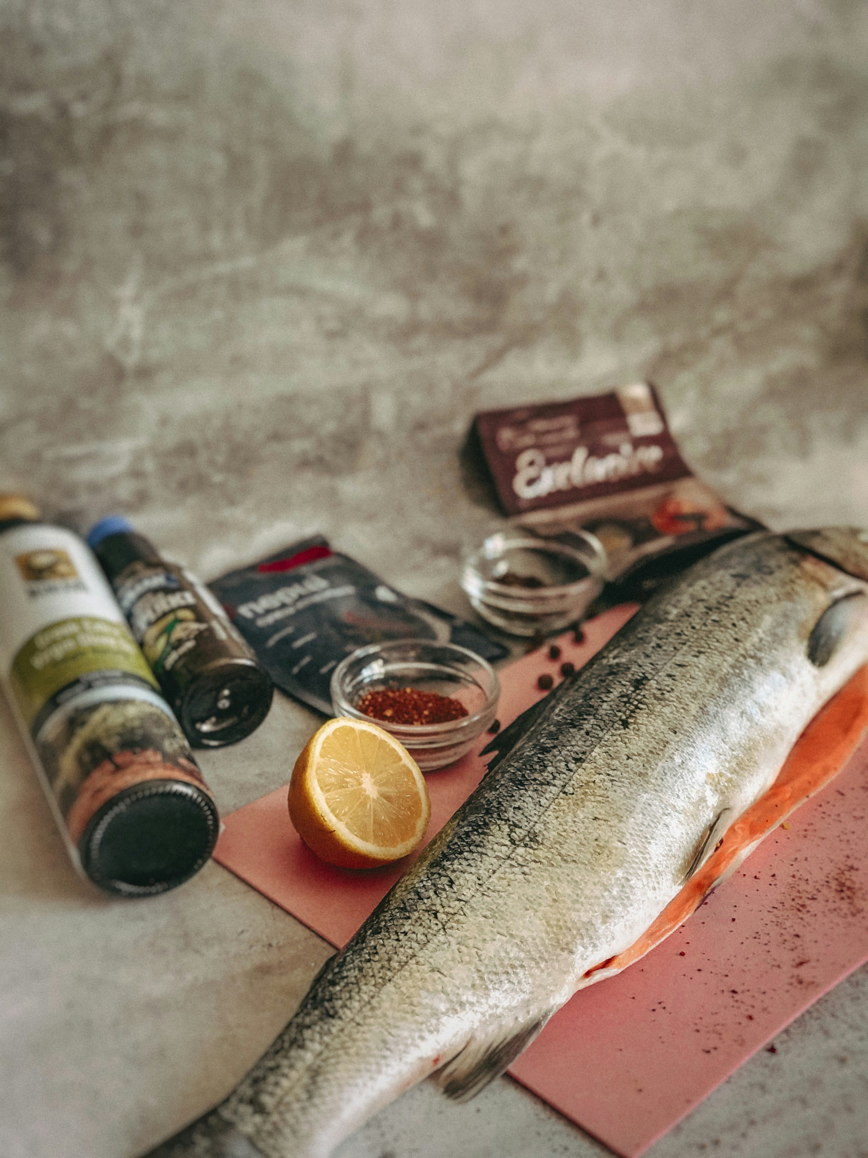 Salmon on a Pink Cutting Board: Lemon Halves and Spices in a Kitchen Still-Life