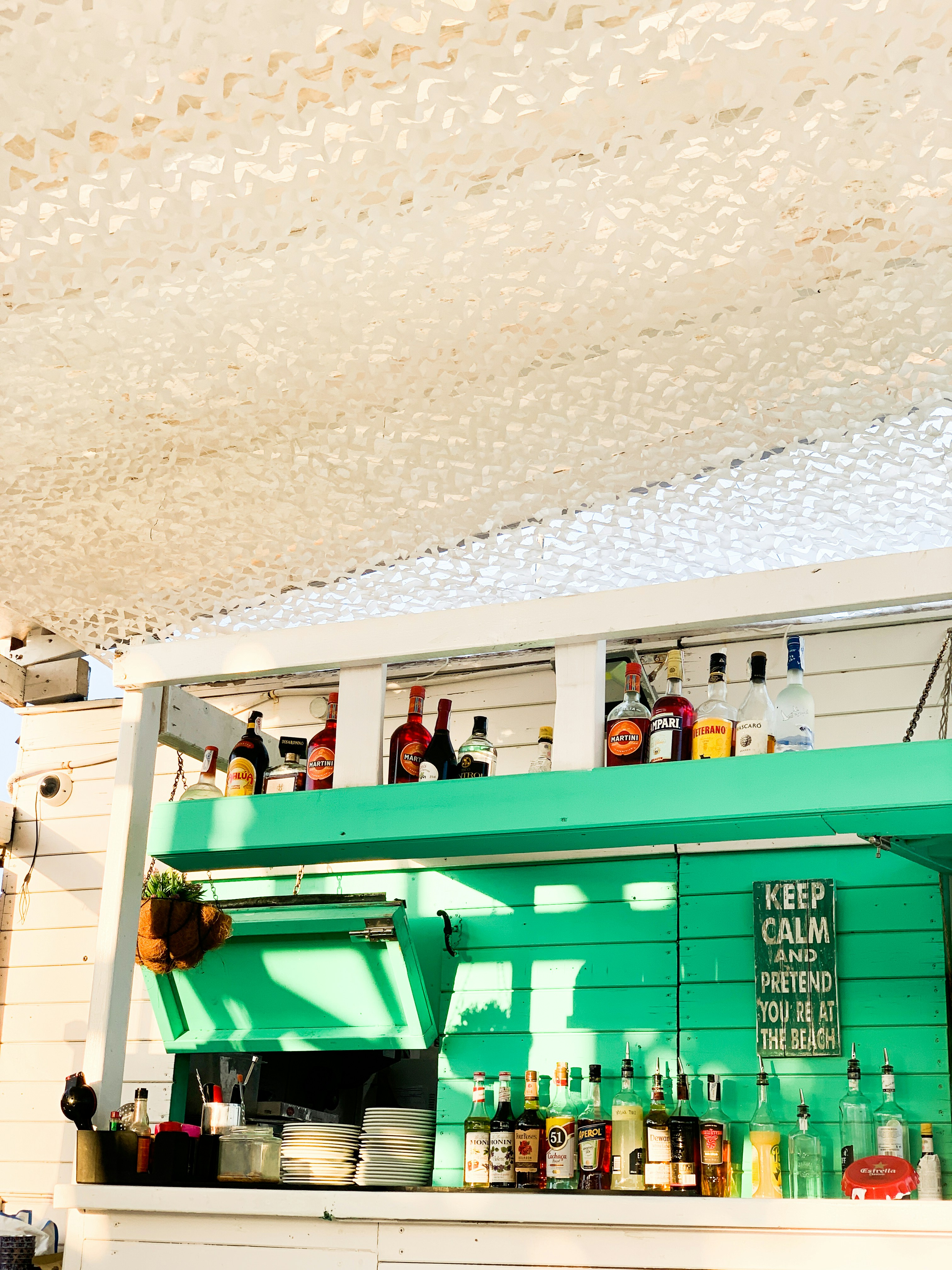 Turquoise Barfront Under a Dappled Roof