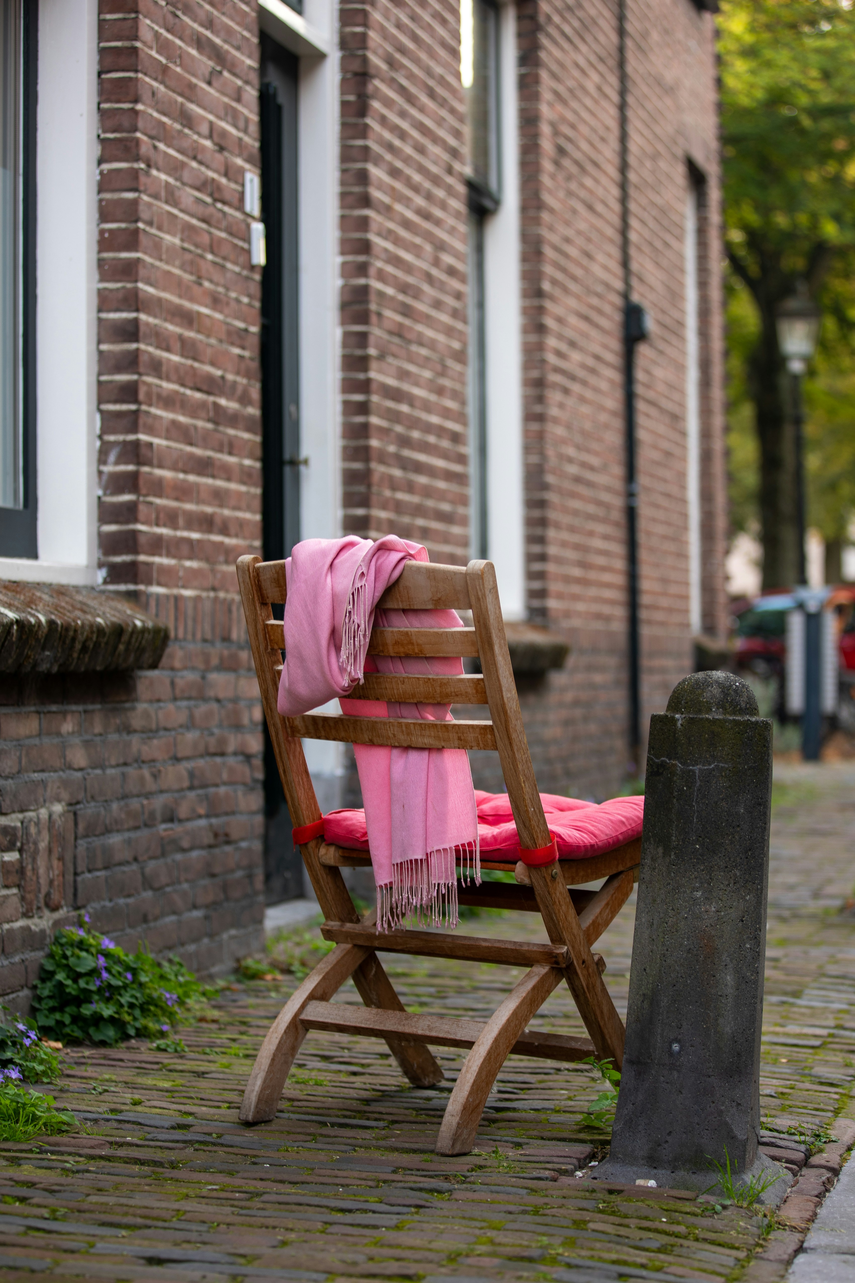 Pink Shawl on a Brick Street Chair: A Quiet Urban Moment
