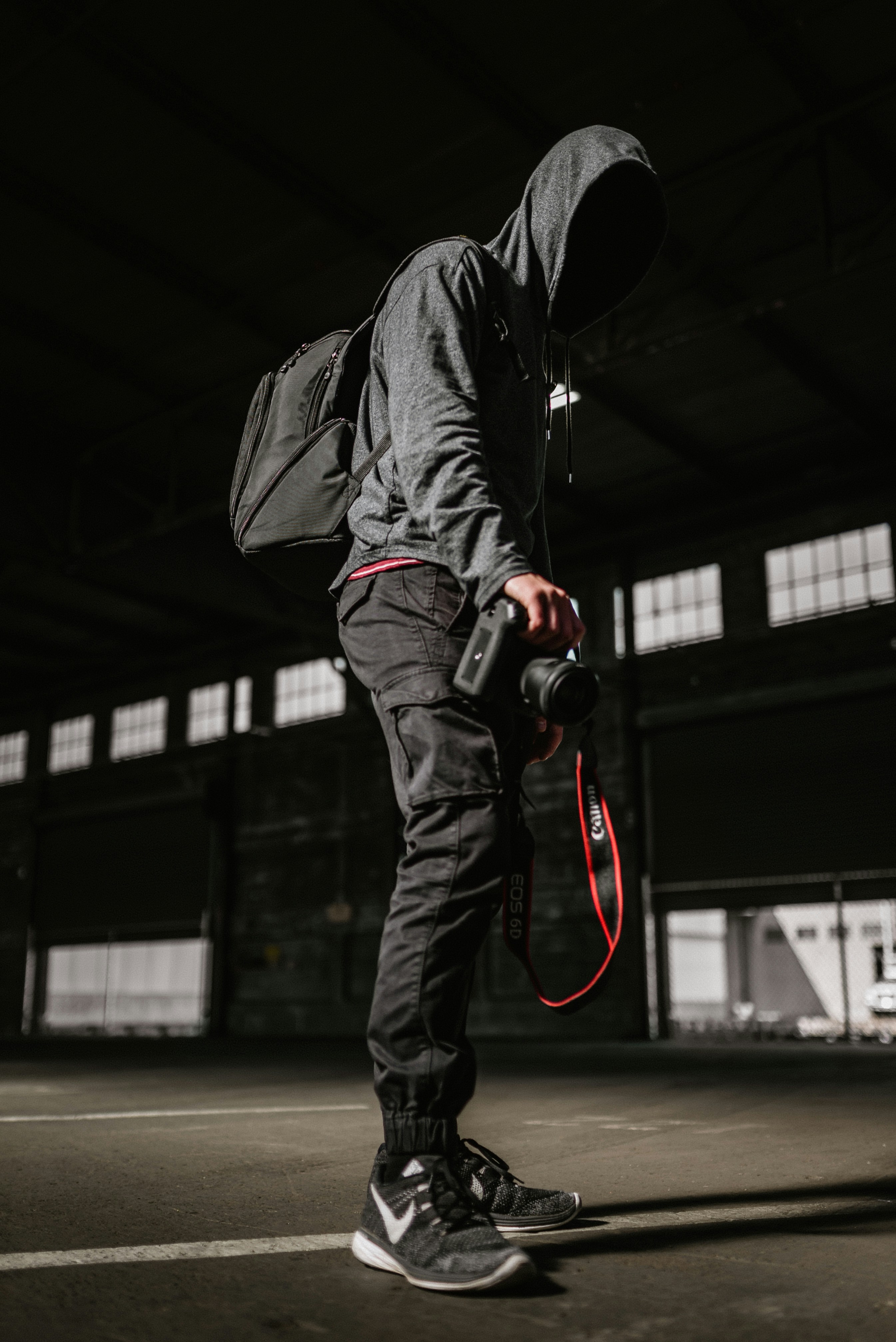 Silent Vessel: A Hooded Photographer in Shadowed Studio