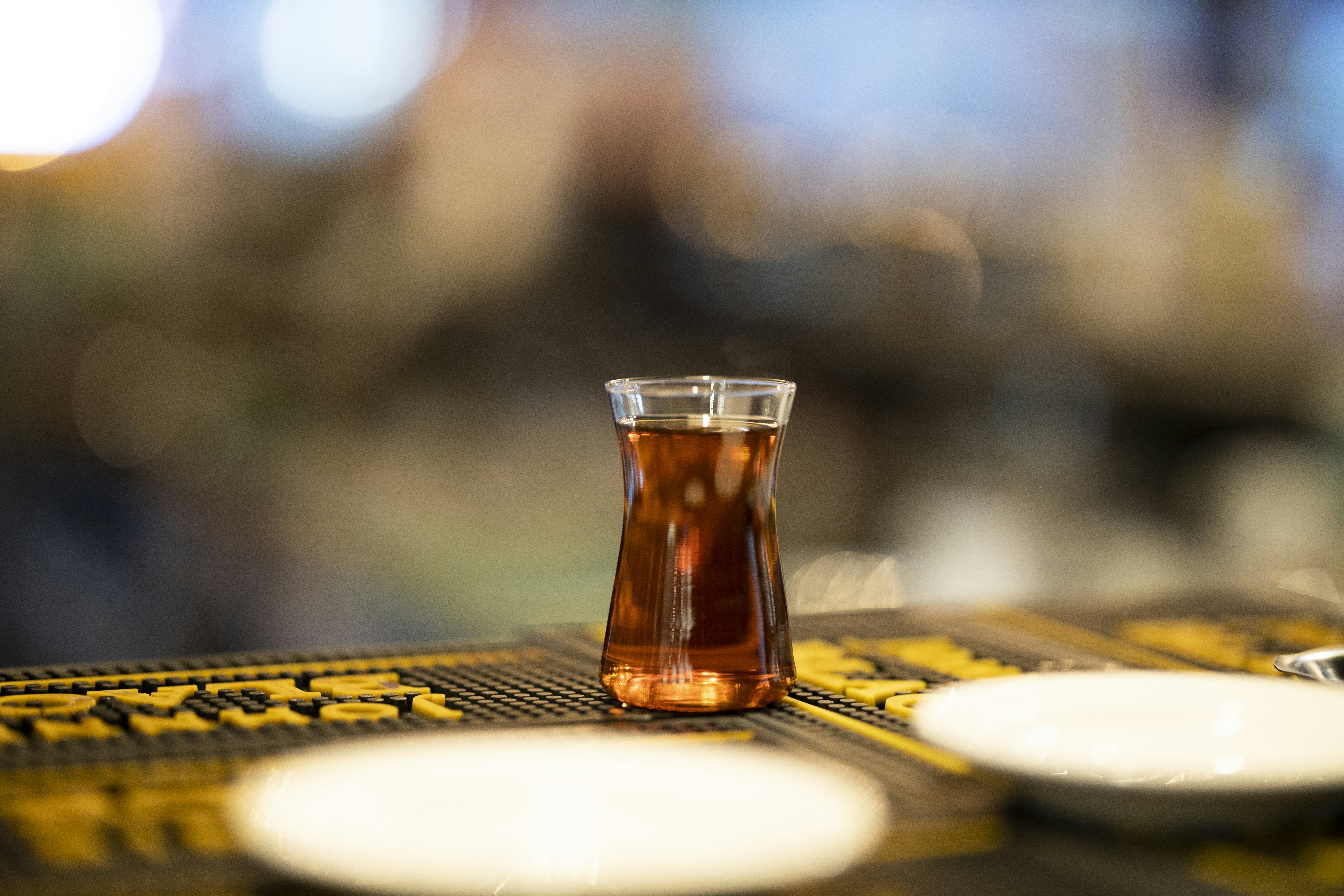 A solitary tea glass: amber glow in a dim bar
