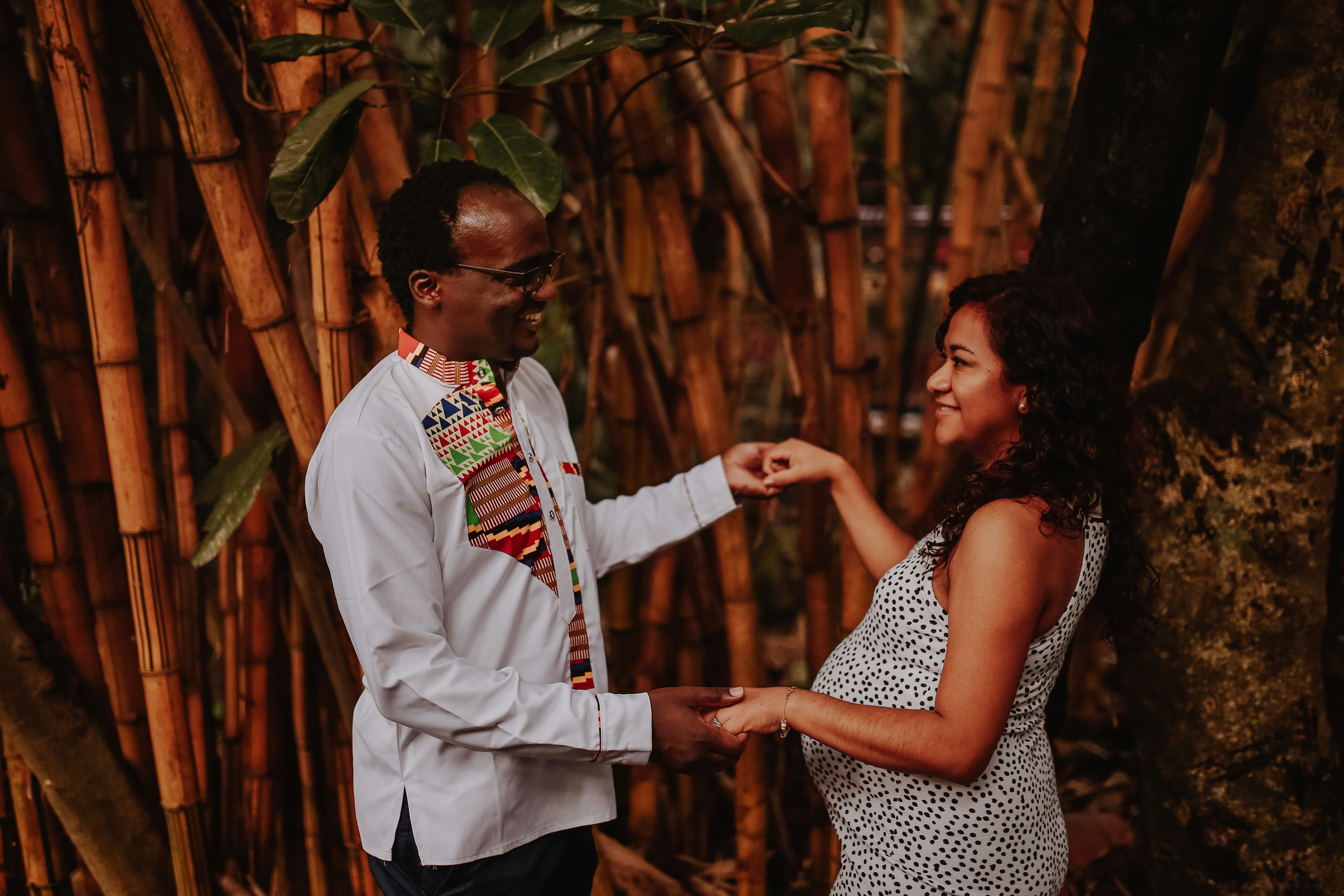 Couple sharing a joyful moment surrounded by tall bamboo stalks.