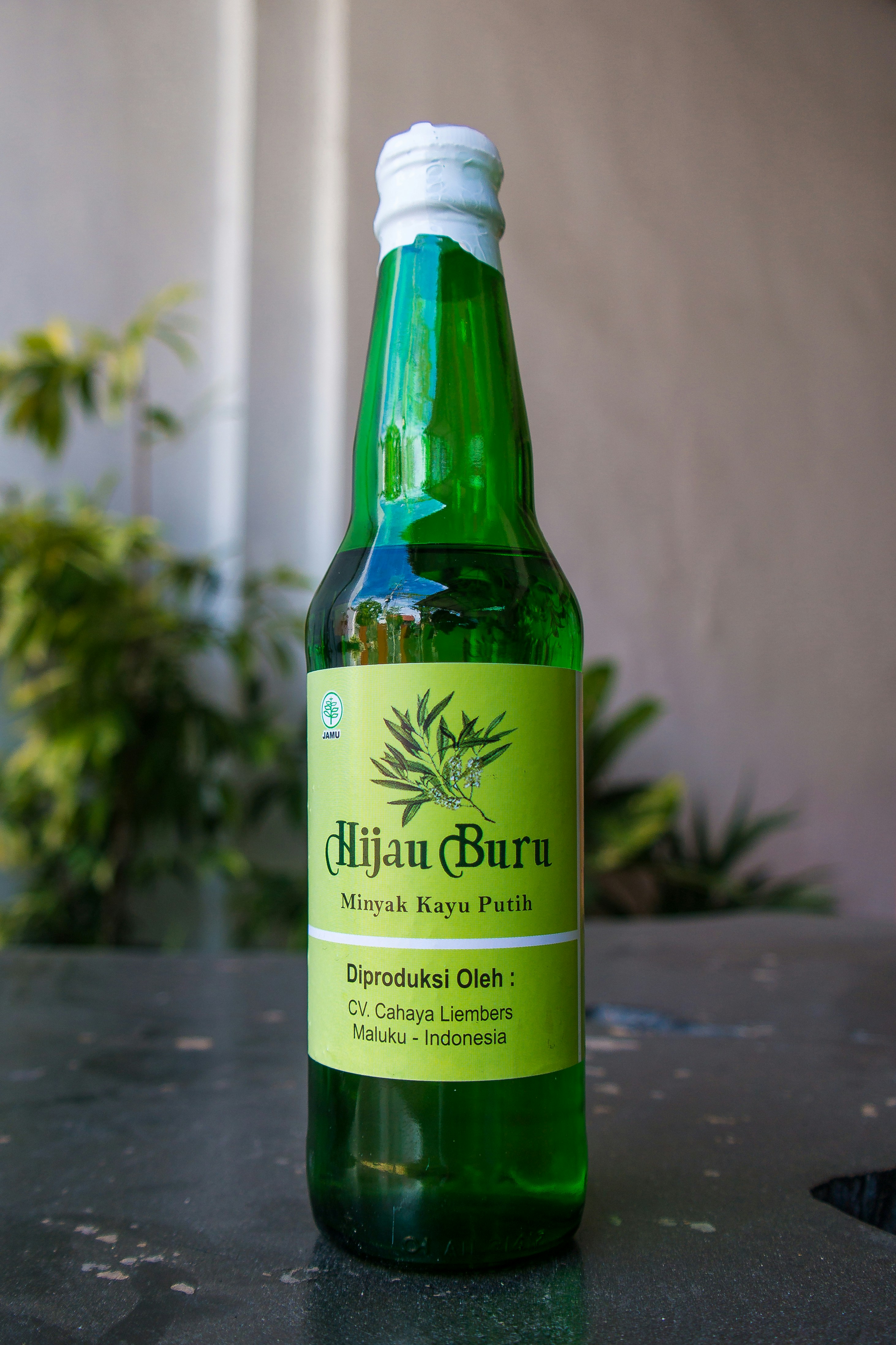 Verdant Label, Quiet Spotlight: A Green Bottle on a Weathered Table