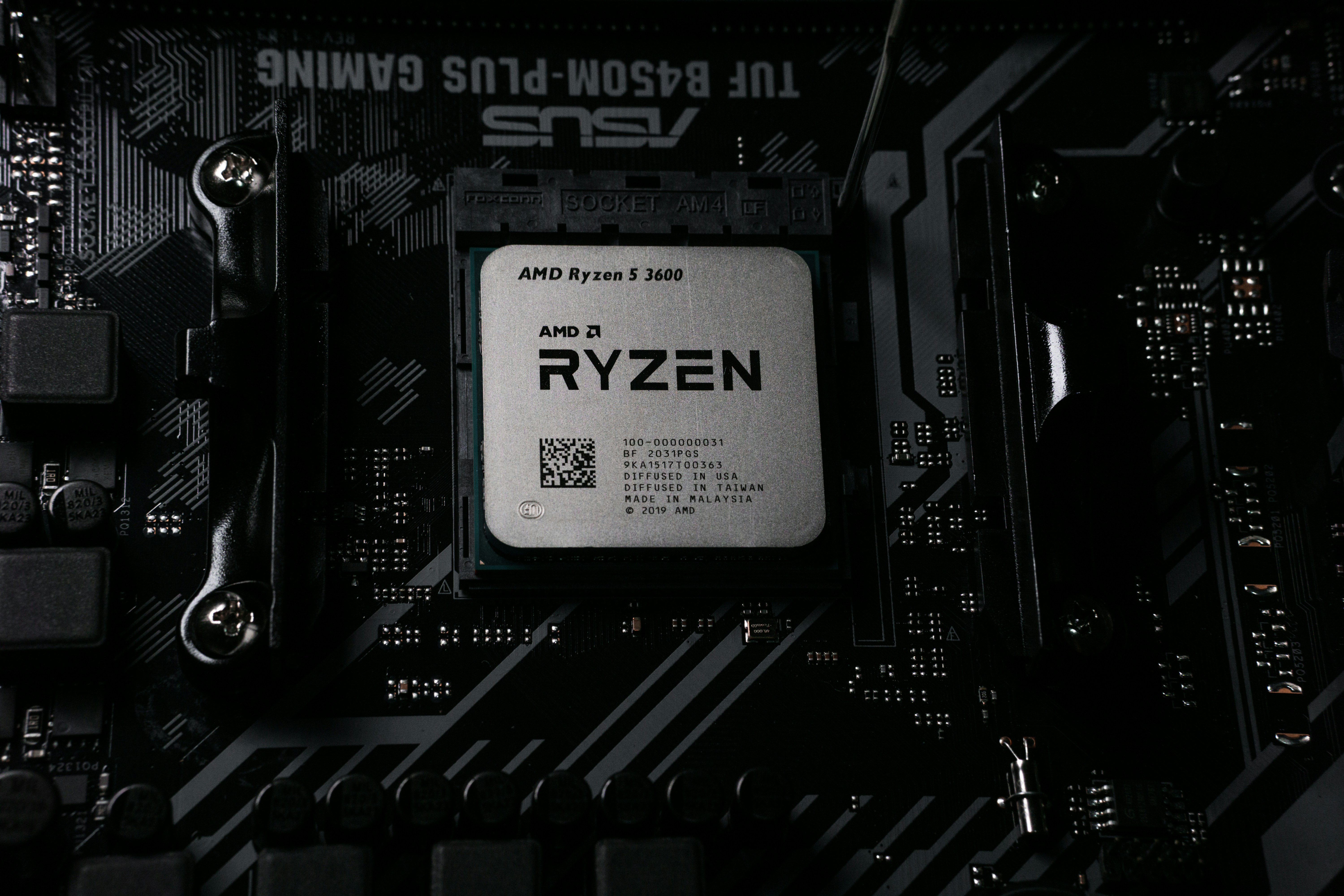 AMD Ryzen 5 3600 processor seated on an ASUS motherboard, showcasing intricate circuitry and components.